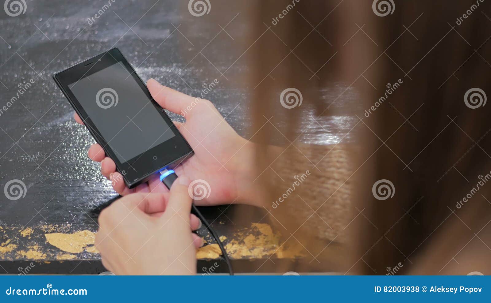 Woman`s Hand Plugging Black Lightning Charging Cable into Smartphone ...