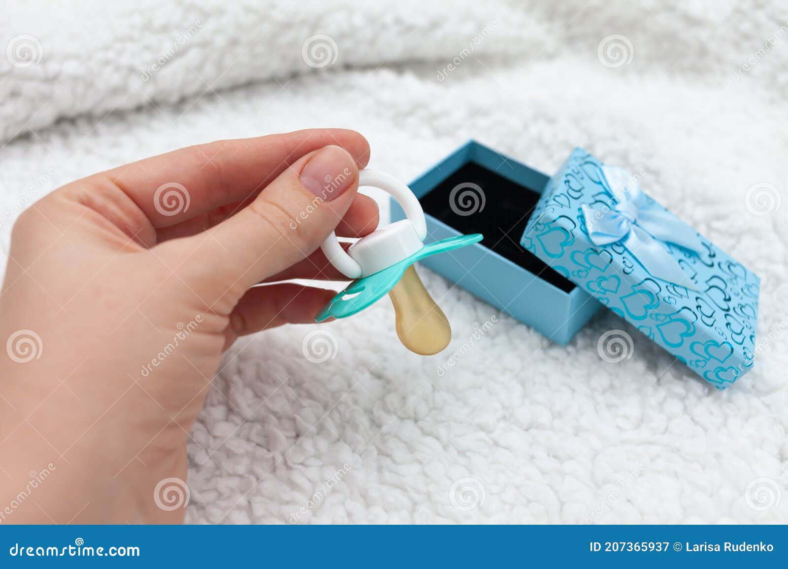 Woman`s Hand Takes a Blue Pacifier from a Gift Box Stock Image - Image ...