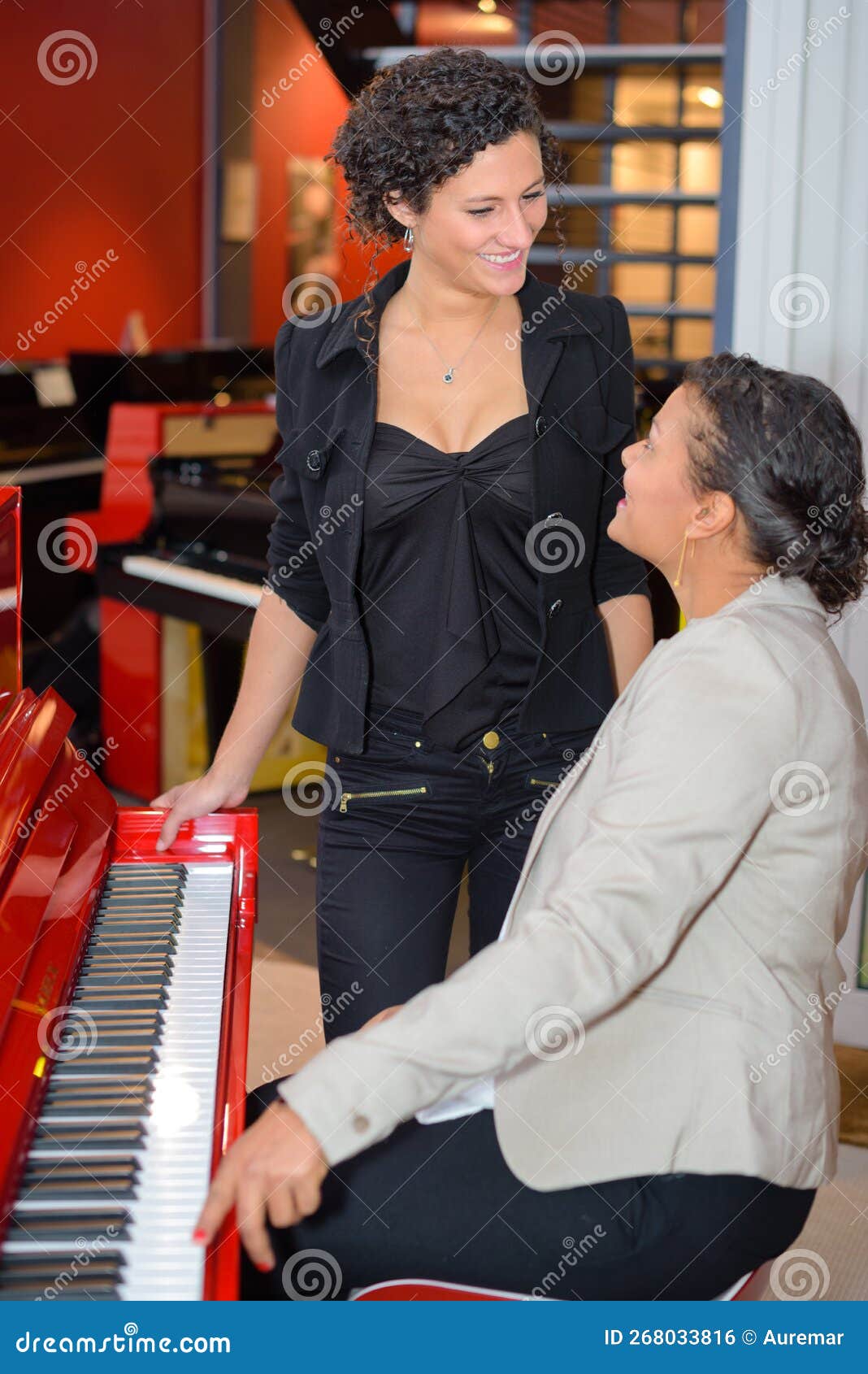 Woman sat at red piano stock photo. Image of ethnicity - 268033816