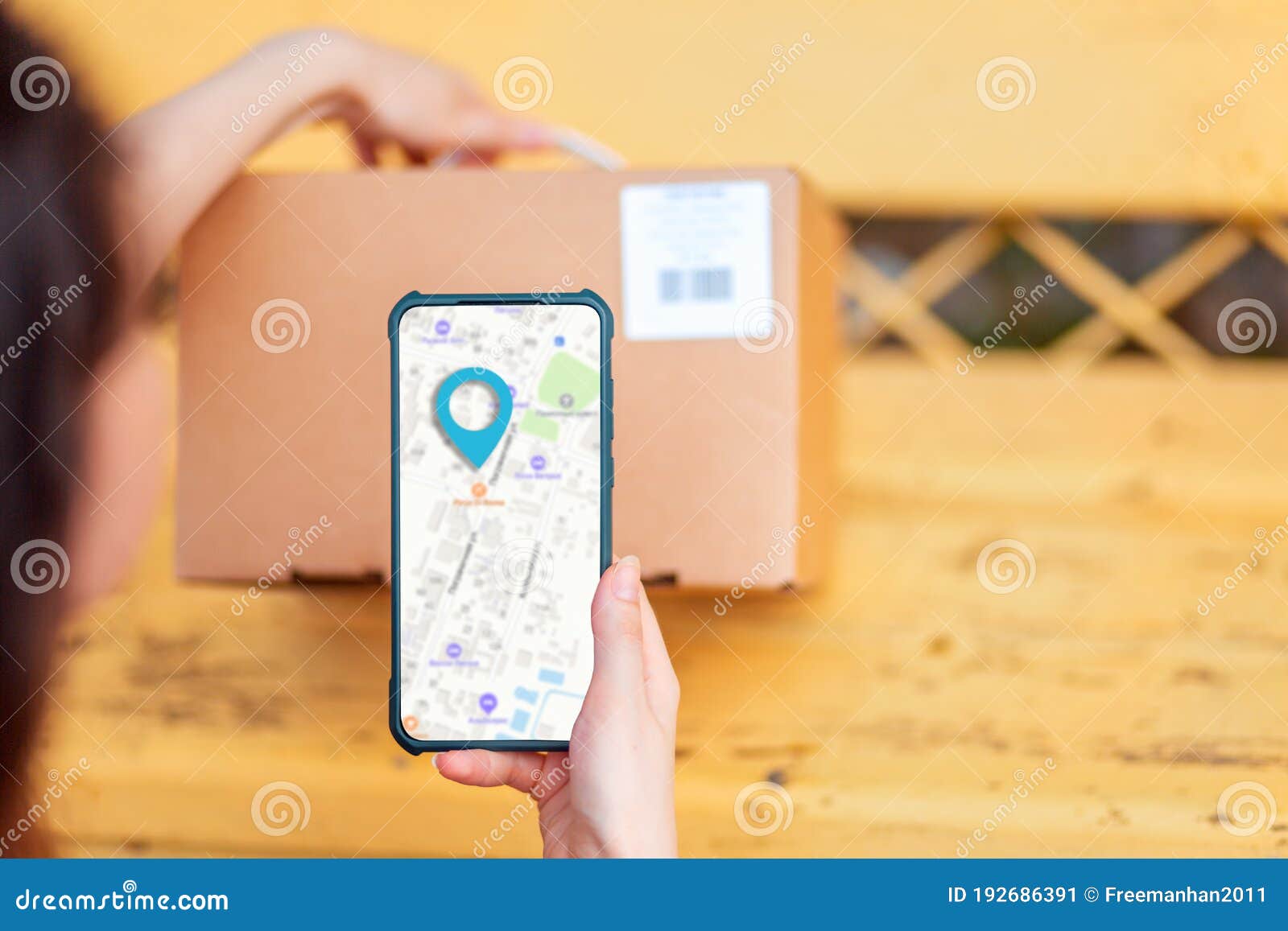 A Woman Scans The Parcel Code Using Her Smartphone. Online Map On The 
