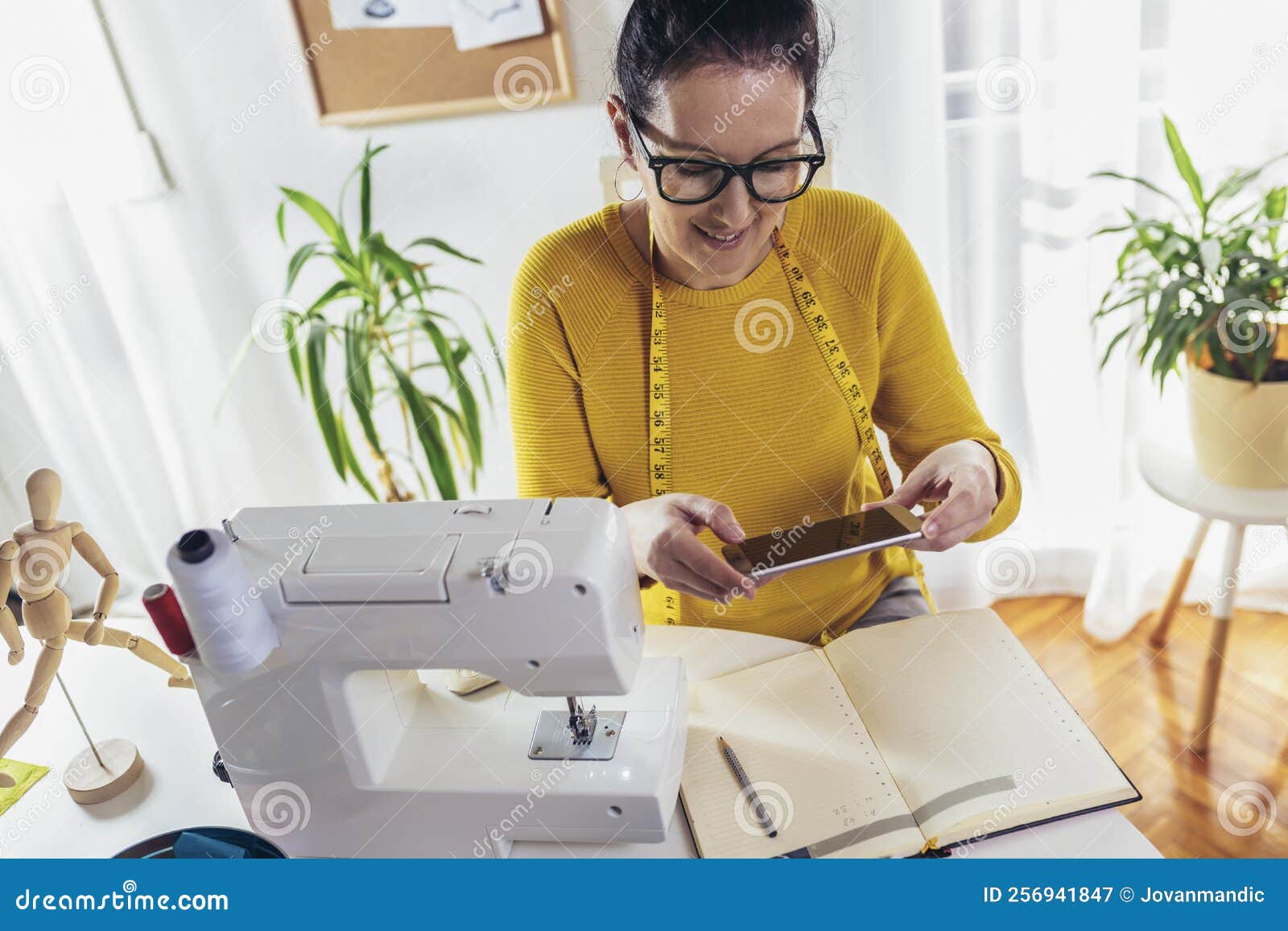 Woman Sewing on a Sewing Machine at Her Home Using Phone Stock Image ...