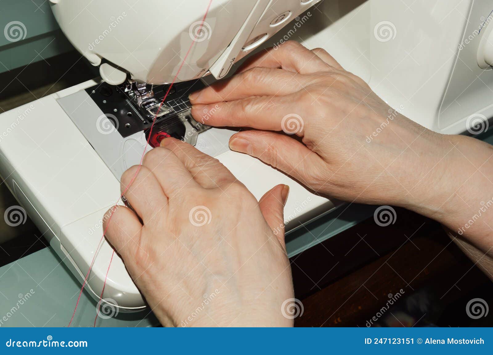 A Woman Sews on a Sewing Machine. Hands Thread the Thread. Stock Image ...