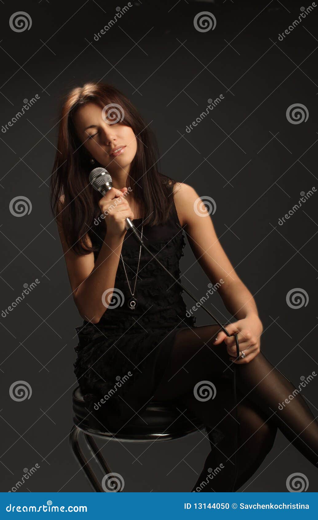 Woman Singing into Microphone Stock Photo - Image of holding, evening ...