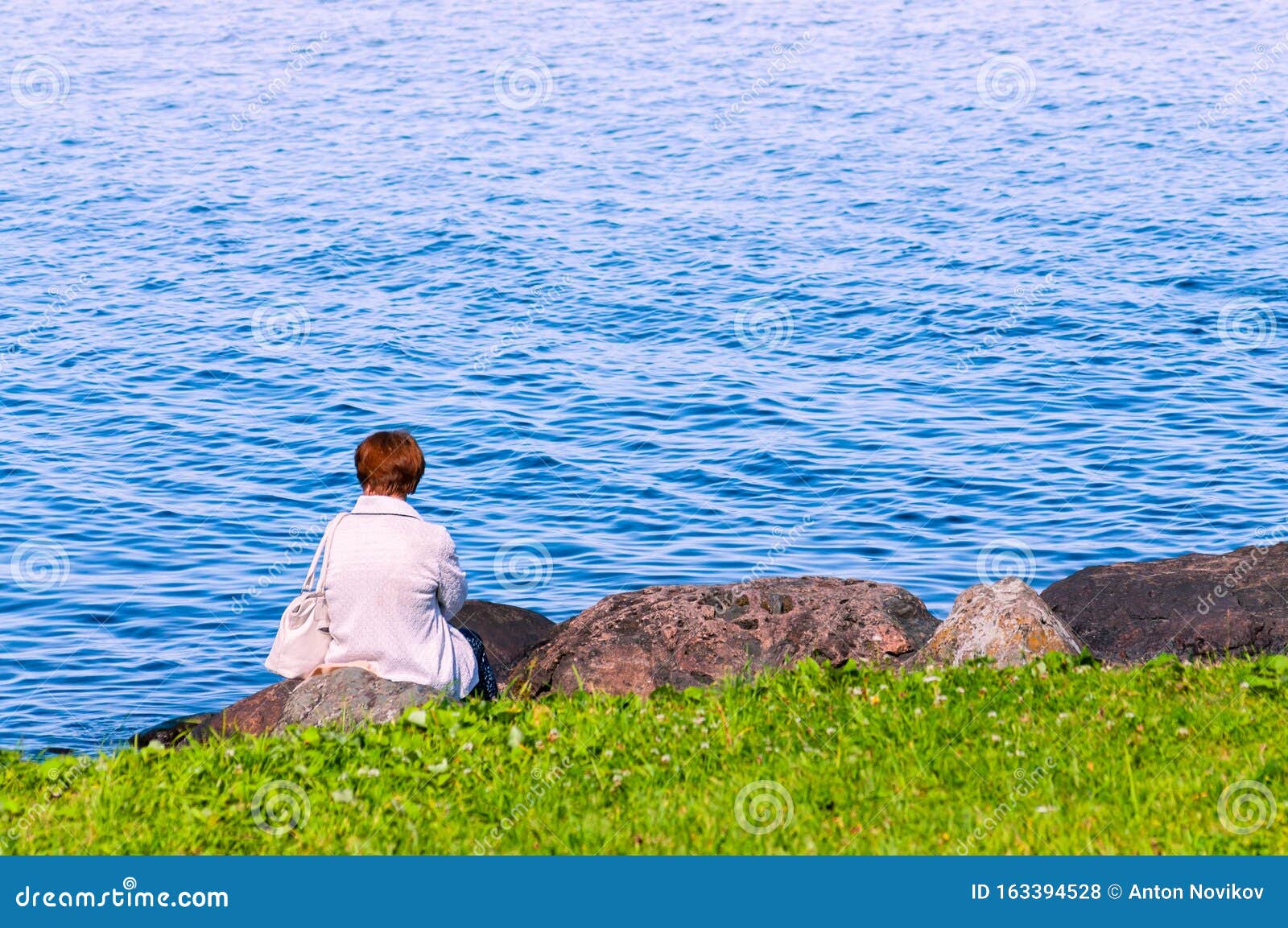 Woman Sits on a Stone on the Shore Stock Photo - Image of nature, shore ...