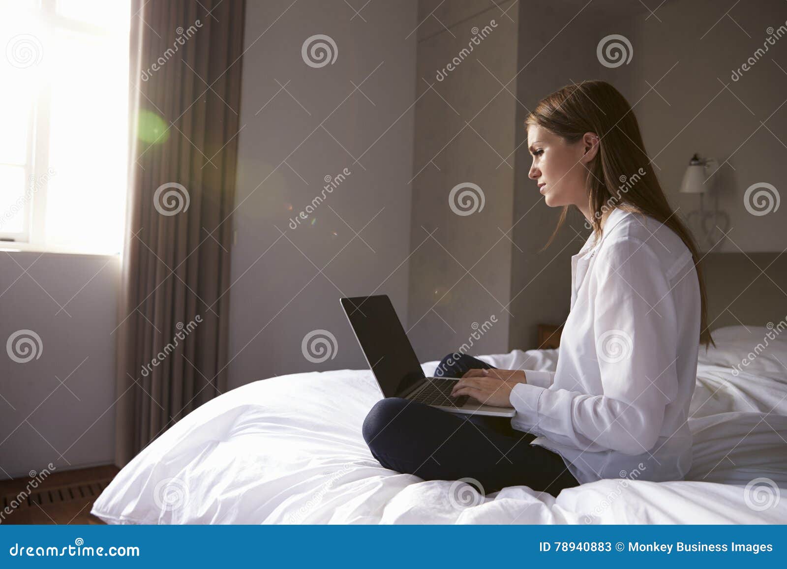 Woman Sitting on Bed in Bedroom Using Laptop Computer Stock Image ...