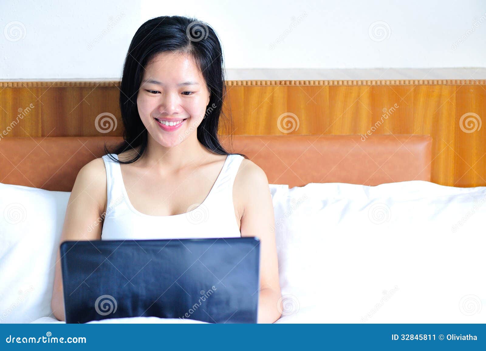 Woman Sitting on the Bed Using Her Computer Stock Image - Image of ...