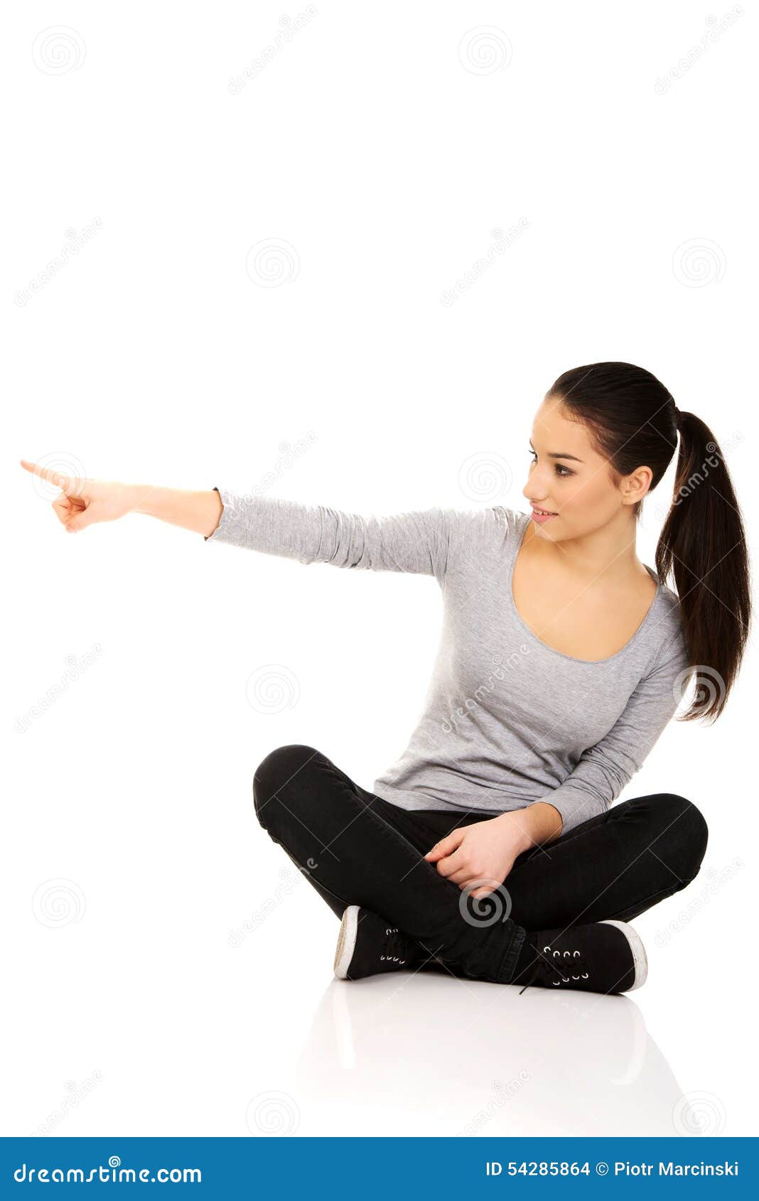 Woman Sitting Cross Legged Pointing Aside. Stock Photo - Image of ...