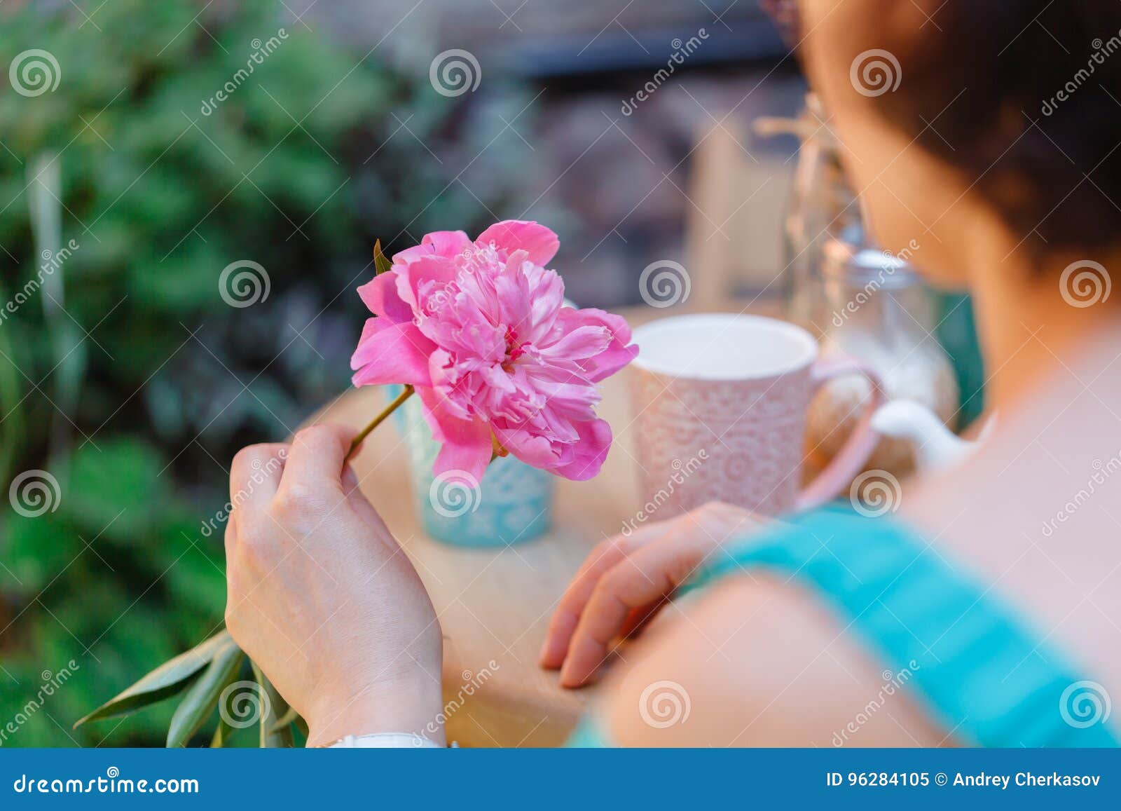 Woman Sitting Drinking Tea at a Cafe with Flower in Hand Stock Image ...