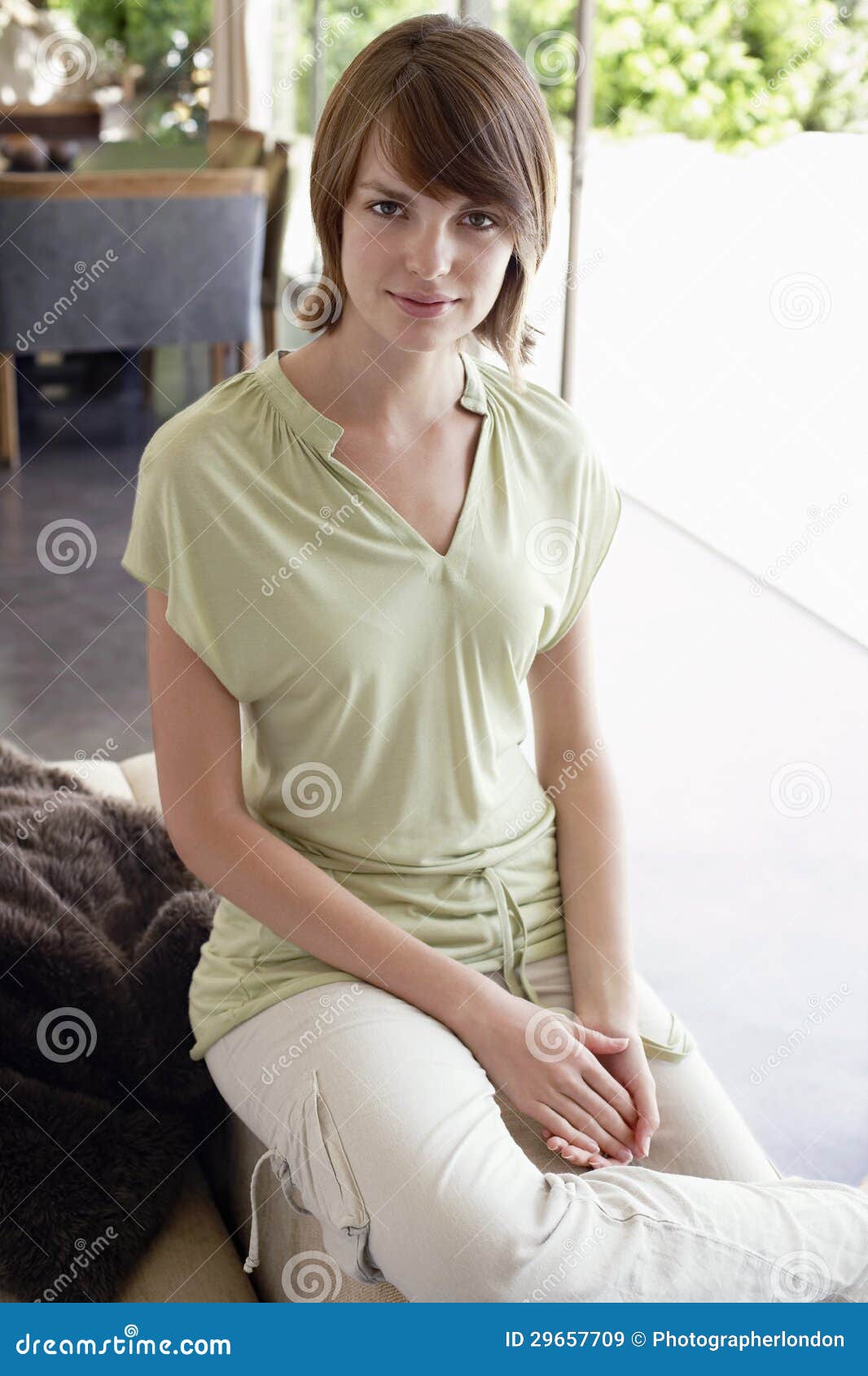 Woman Sitting at Edge of Sofa Stock Image - Image of lifestyle, looking ...