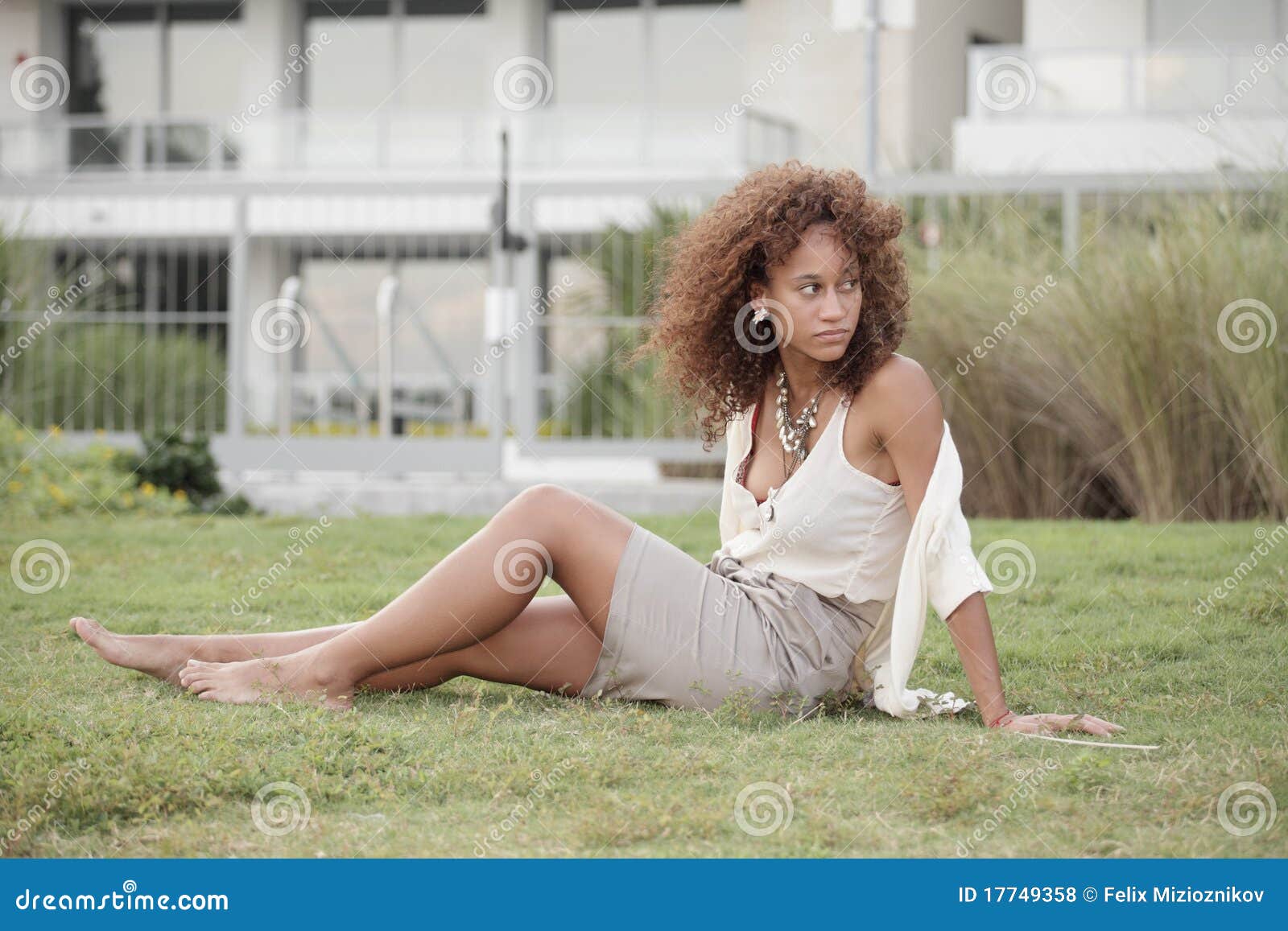 Woman sitting on the grass stock photo. Image of racial - 17749358