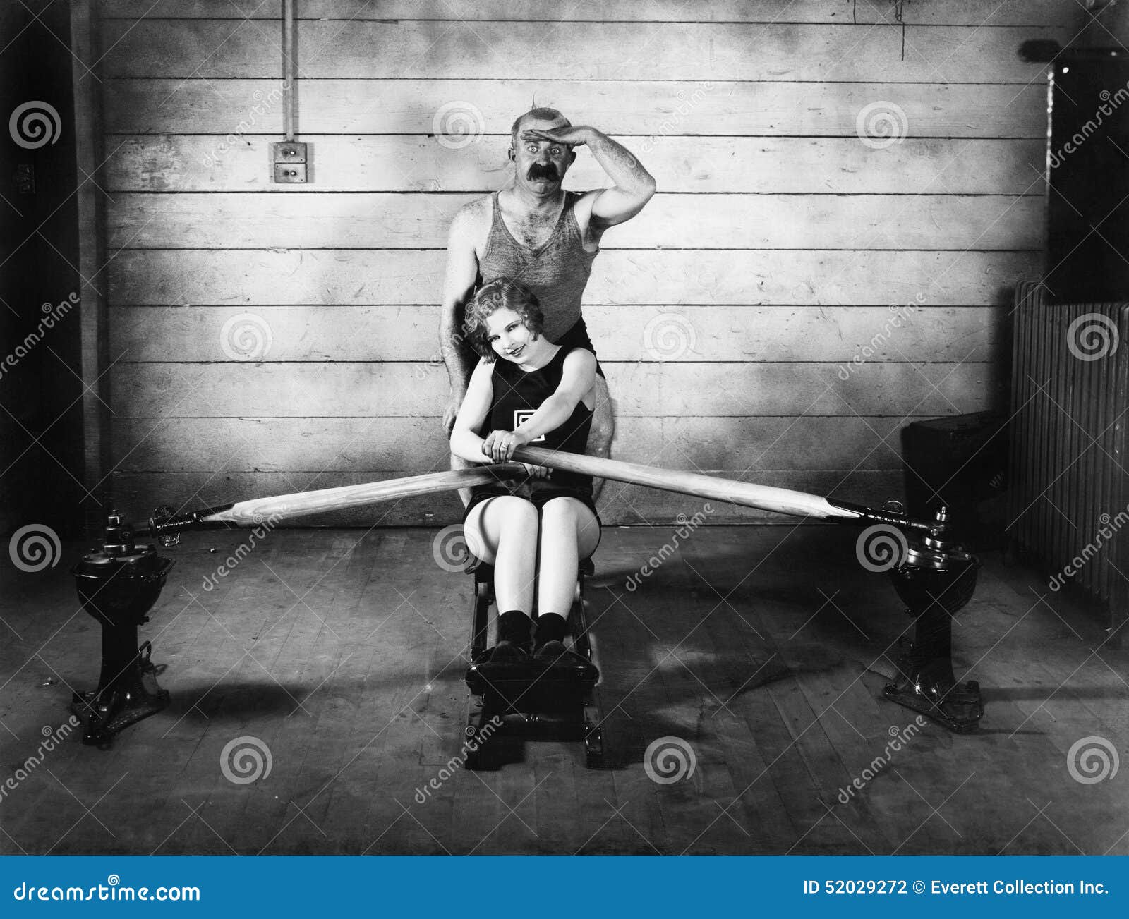 Woman Sitting on a Rowing Machine with a Man Behind Her Stock Photo ...