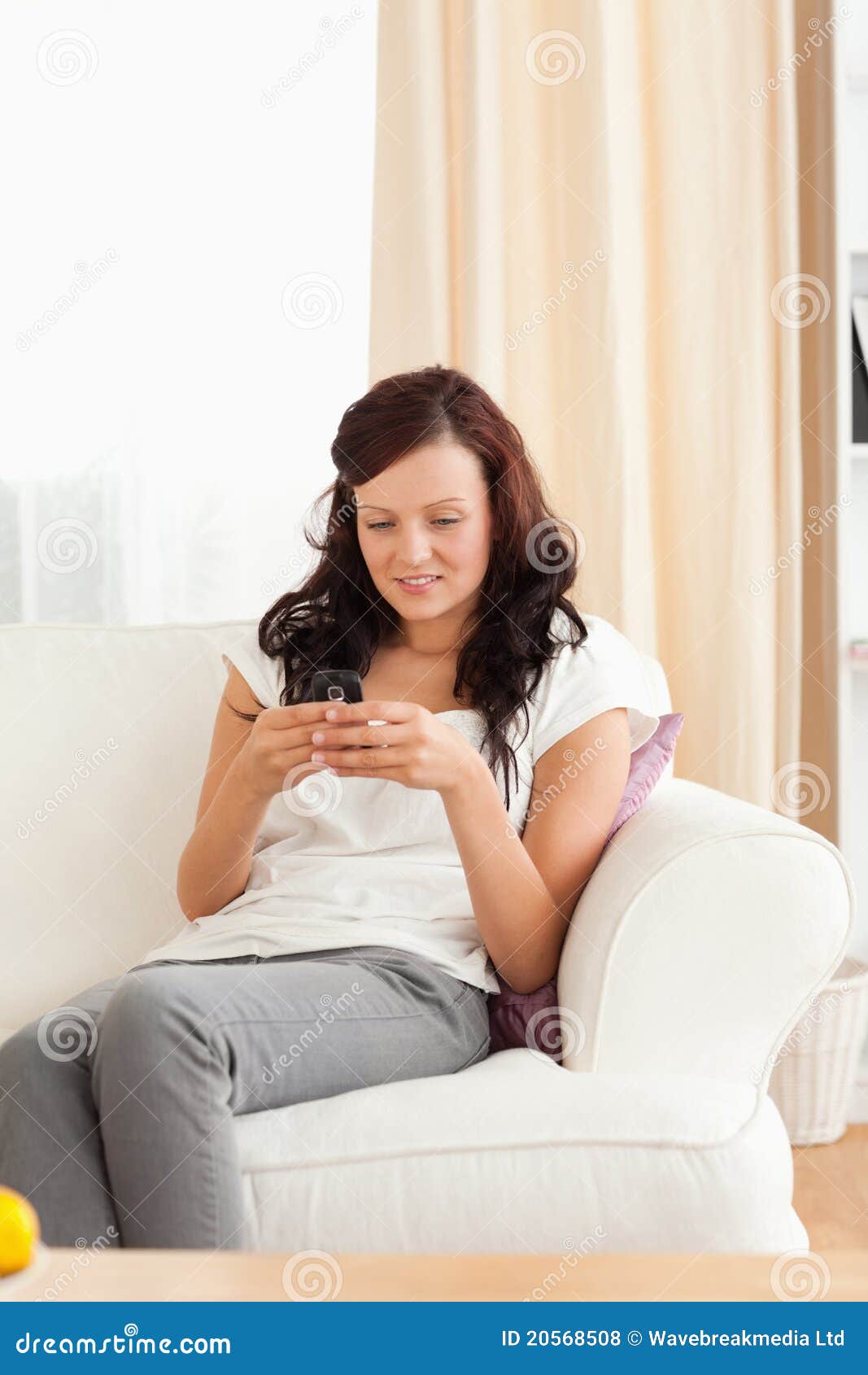 Woman Sitting on a Sofa Texting Stock Photo - Image of room, texting ...