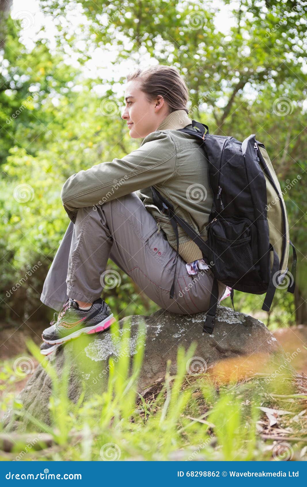 Woman sitting on a stone stock photo. Image of grass - 68298862