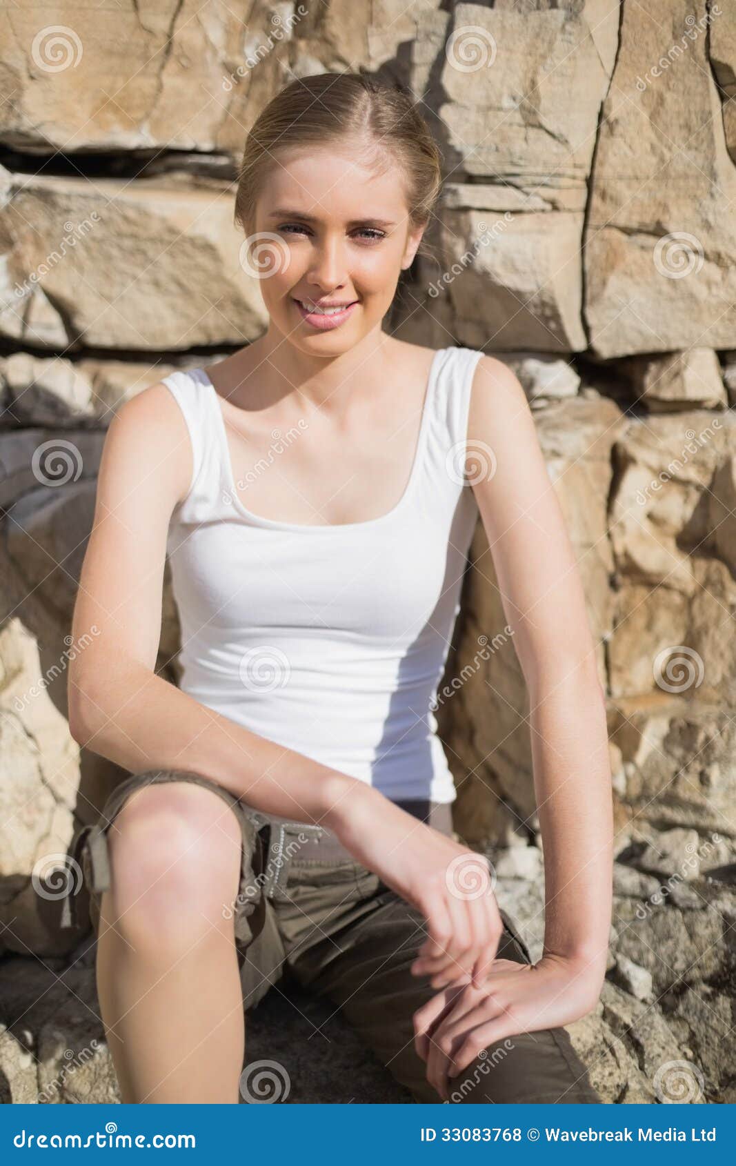 Woman Sitting on Stone with Hands on Leg Stock Photo - Image of ...
