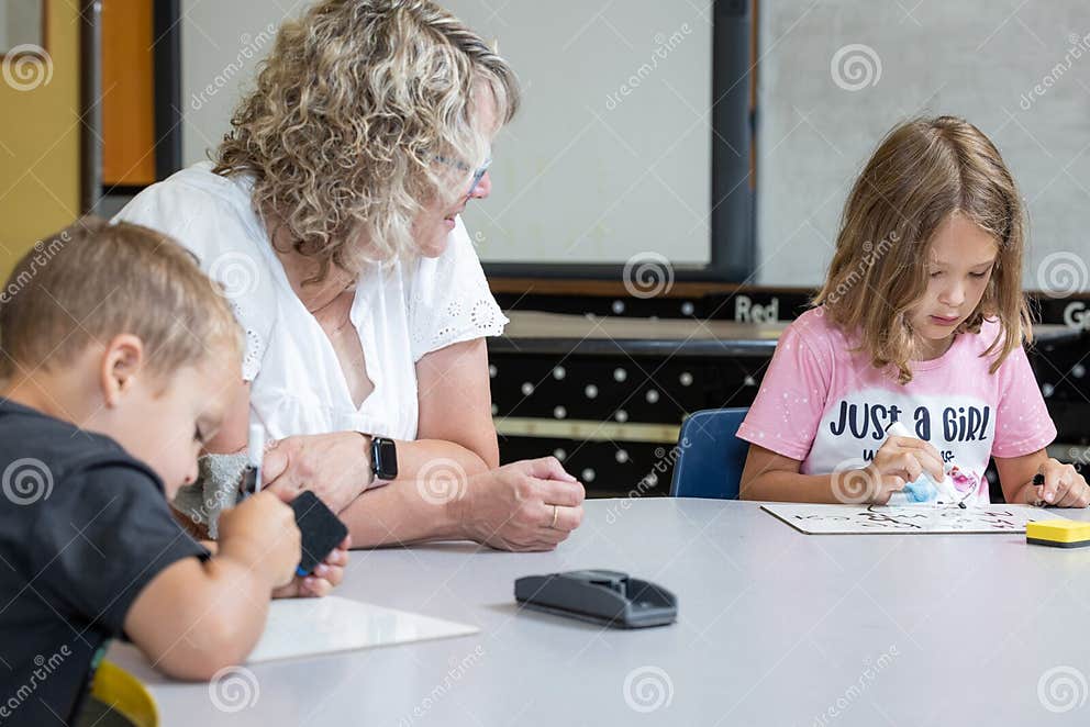 A Woman is Sitting at a Table with Two Children Stock Photo - Image of little, mother: 330293692