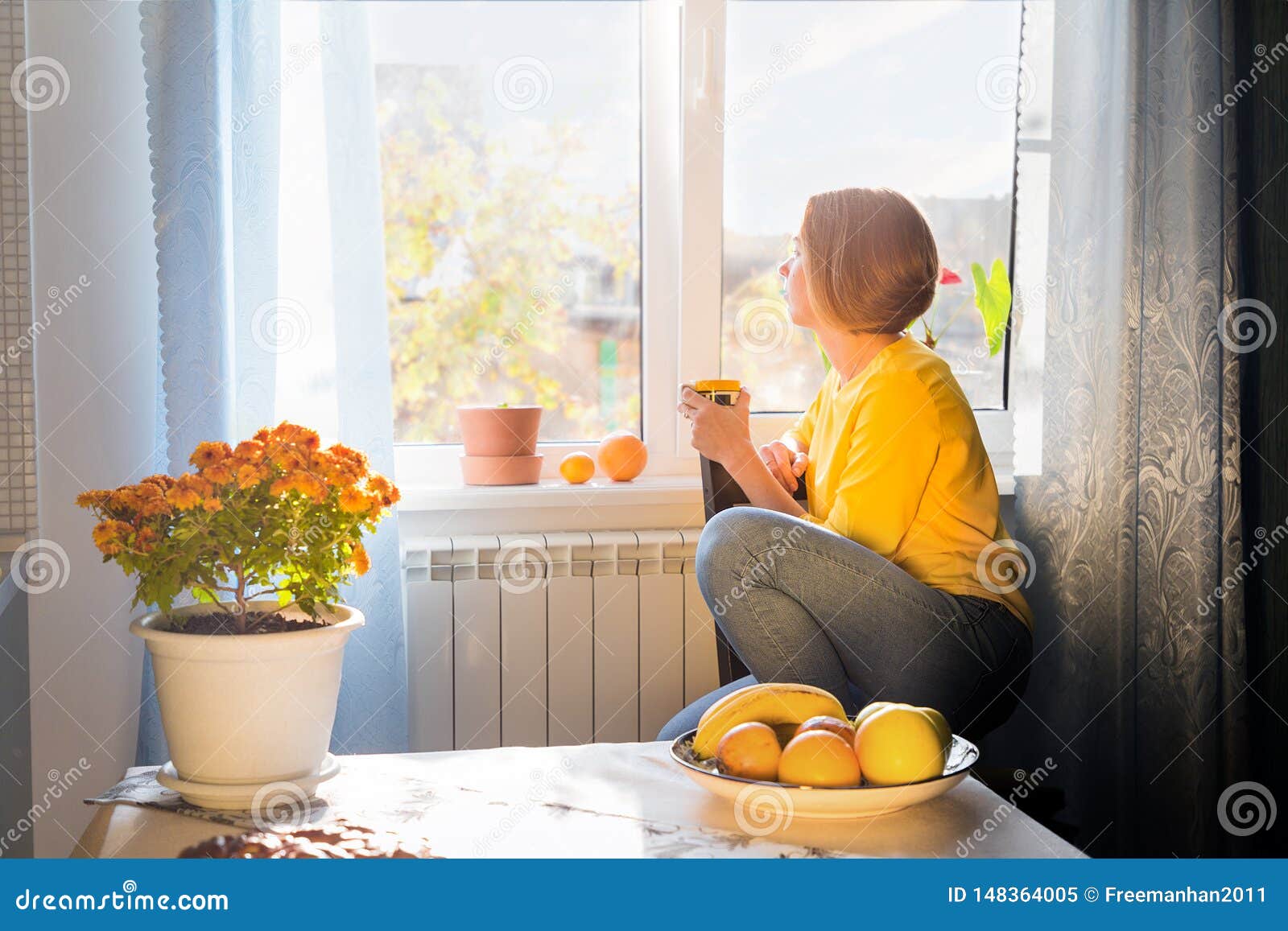 Woman Sitting by the Window and Drinking Tea. Side View Stock Image ...