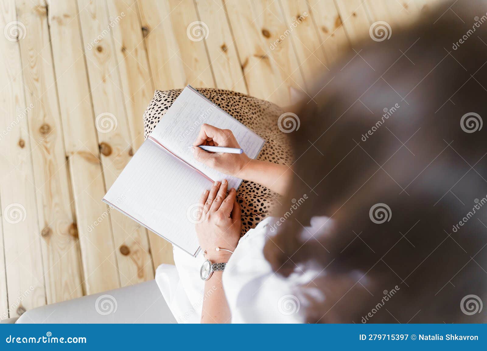 A Woman is Sitting and Writing in a Notebook Stock Image - Image of ...
