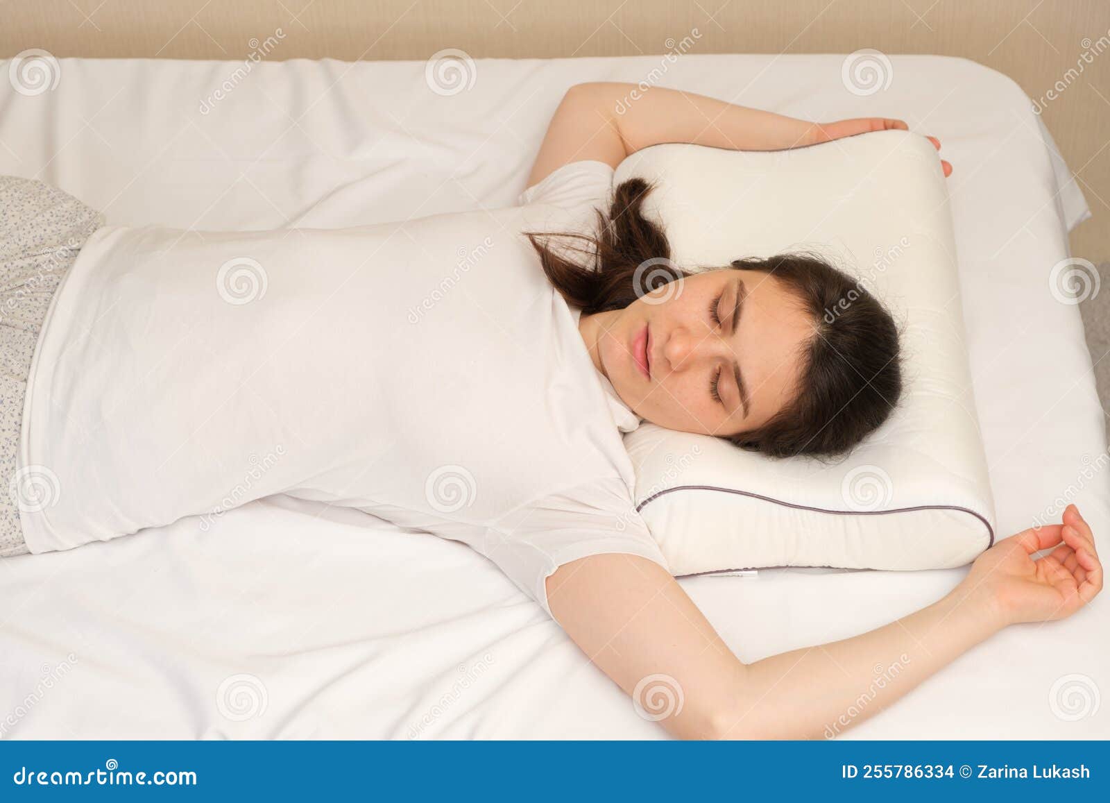 A Woman Sleeps on an Orthopedic Pillow Made of Memory Foam, Lying on a ... A Woman Sleeps on an Orthopedic Pillow Made of Memory Foam, Lying on a ...