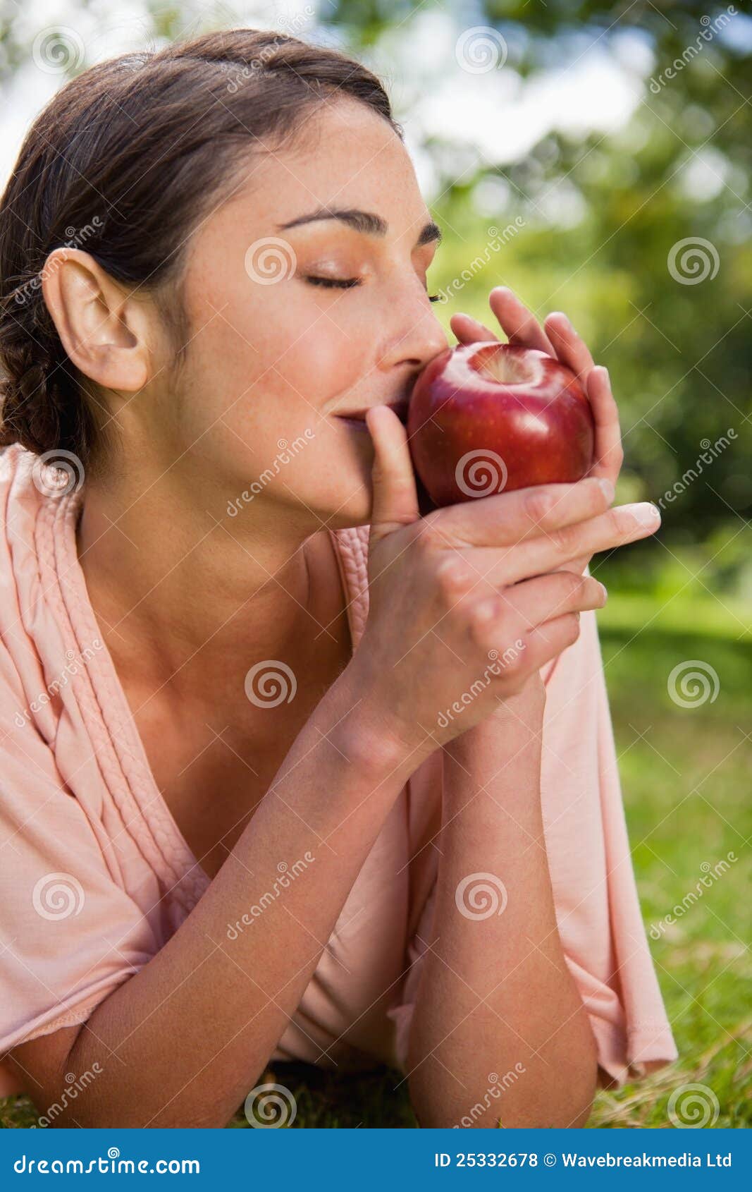 Woman Smells an Apple while Lying in Grass Stock Photo - Image of sunny ...