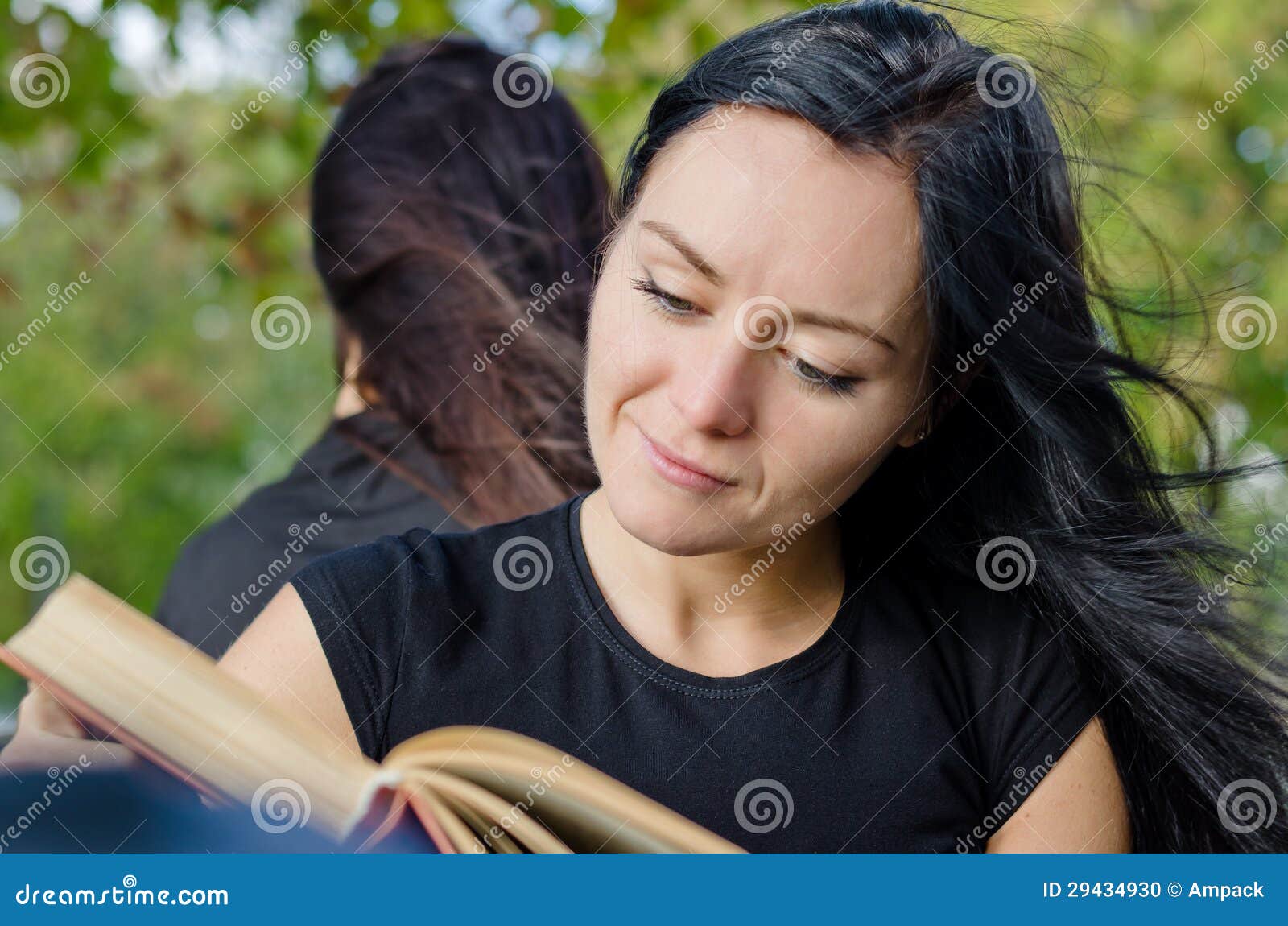 Woman Smiling As she Reads a Book Stock Photo - Image of attractive ...