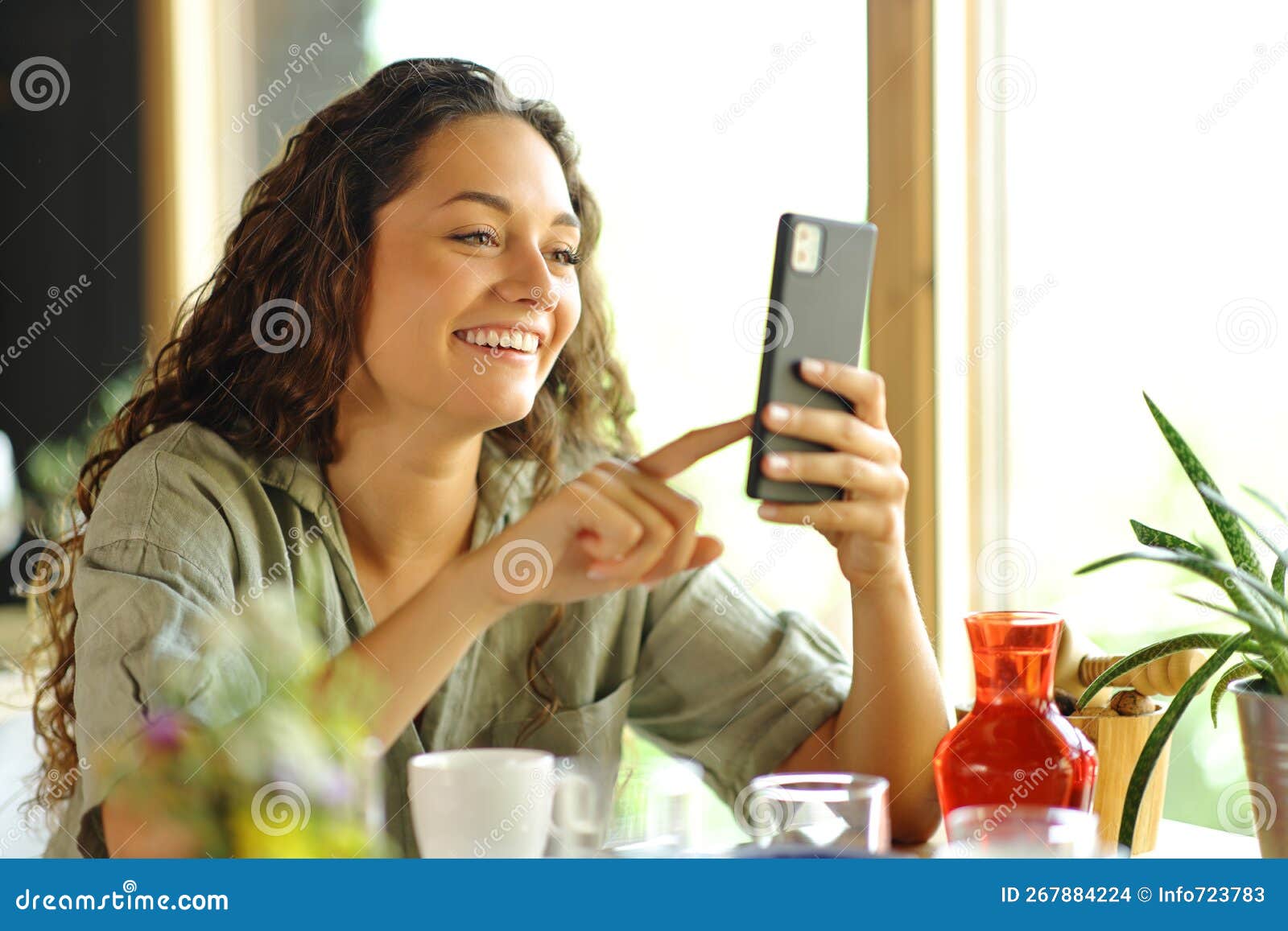 Woman Smiling Using Phone in a Restaurant Stock Photo - Image of mobile ...