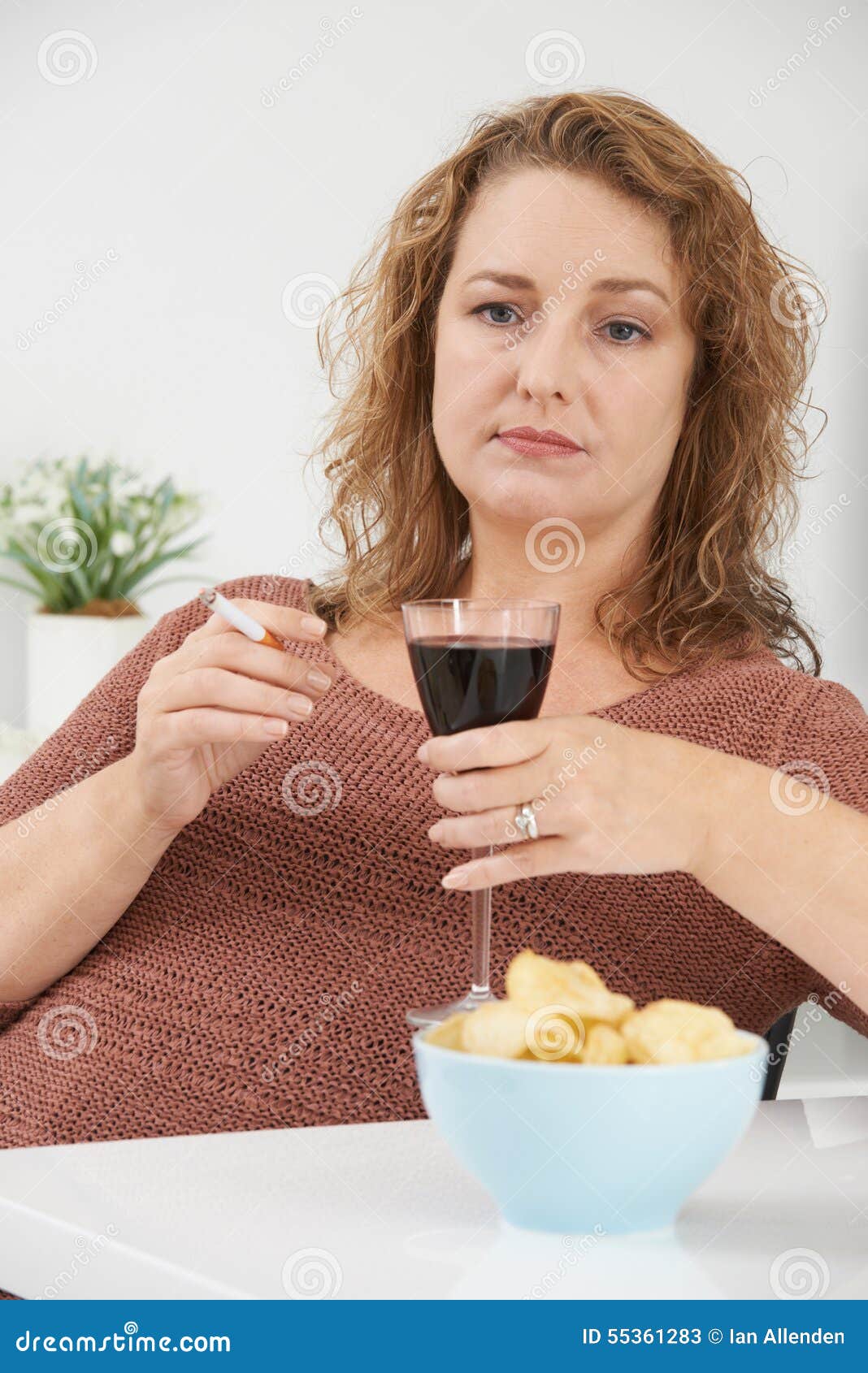 Woman Smoking Cigarette Whilst Drinking Wine and Eating Snacks Stock ...