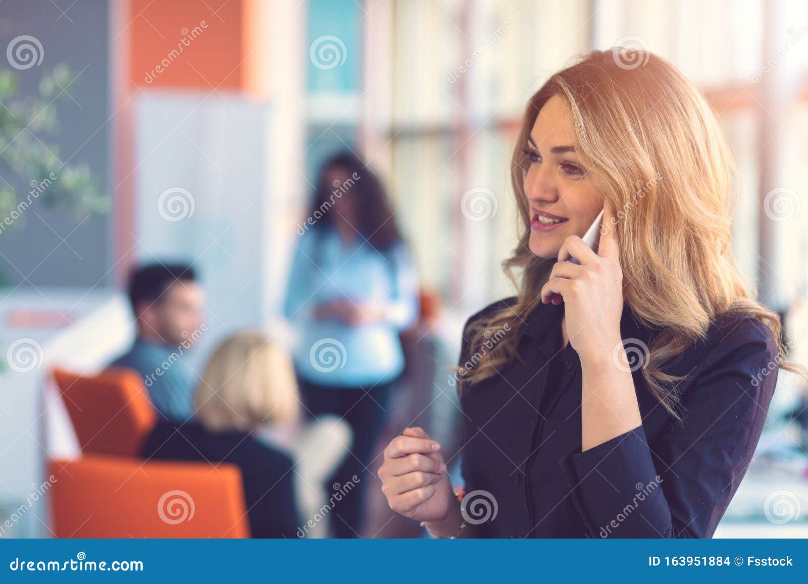 Woman Speaking on Mobile Phone in Front of Team Stock Photo - Image of ...