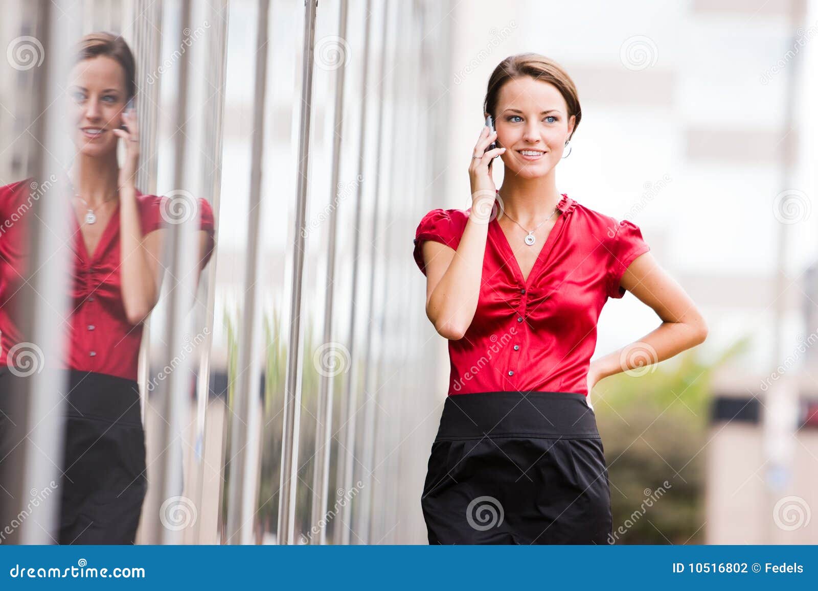 Woman Standing by a Building and Using Cell Phone Stock Photo - Image ...