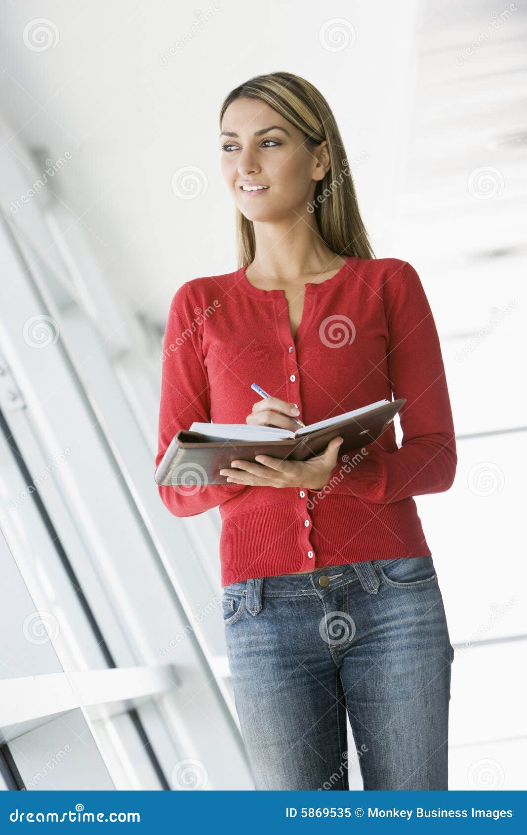 Woman Standing in Corridor Writing in Notebook Stock Image - Image of ...