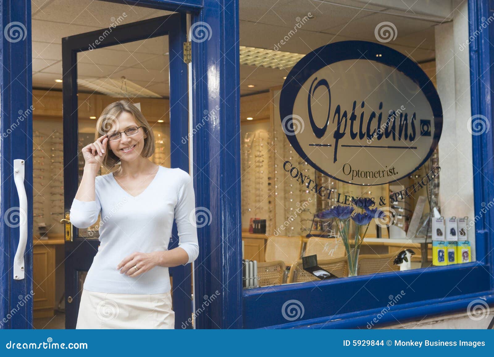 Woman Standing at Front Entrance of Optometrists Stock Photo - Image of ...