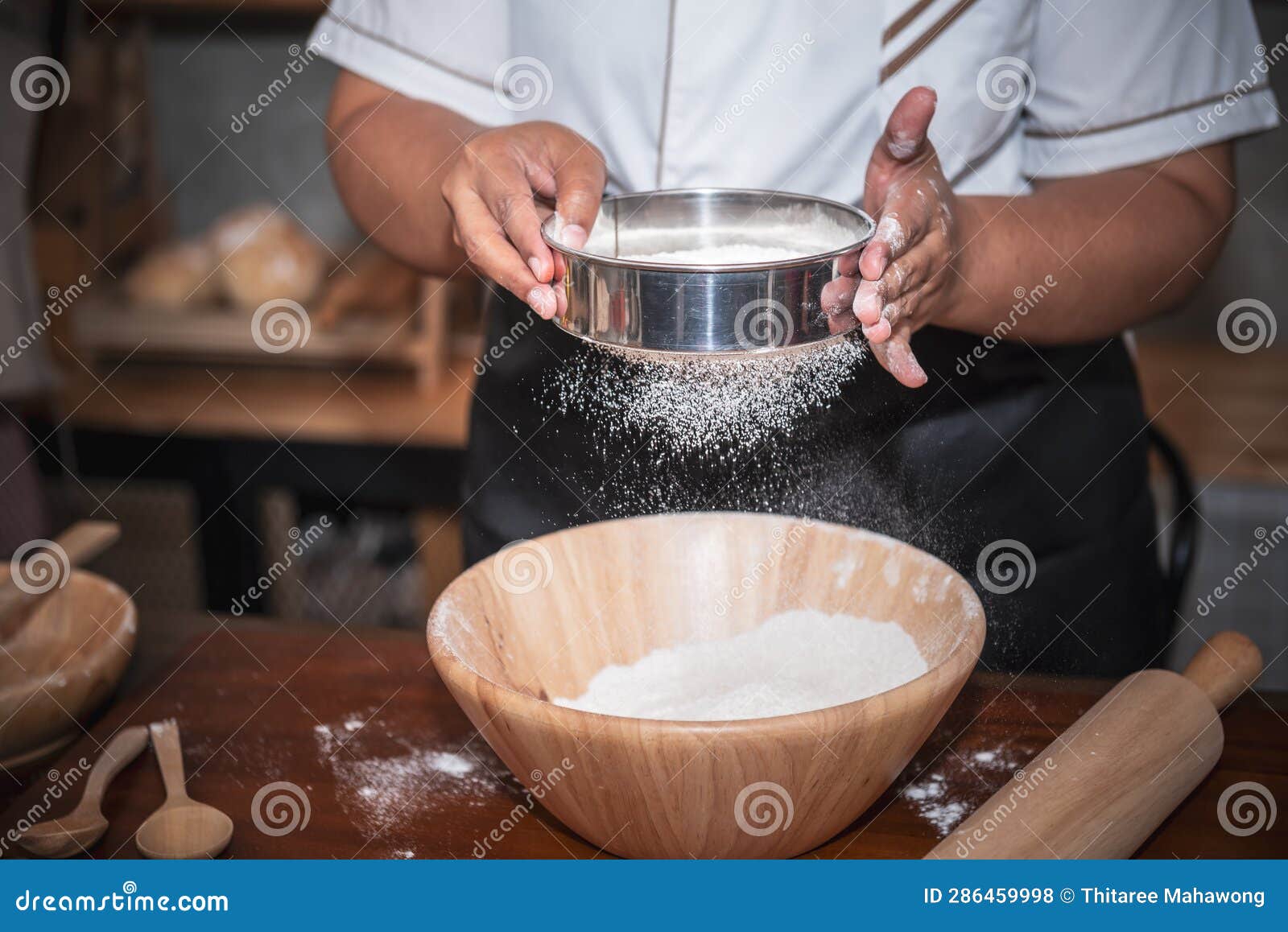 Woman Standing in the Kitchen and Using the Sieve, Sifting the Flour ...