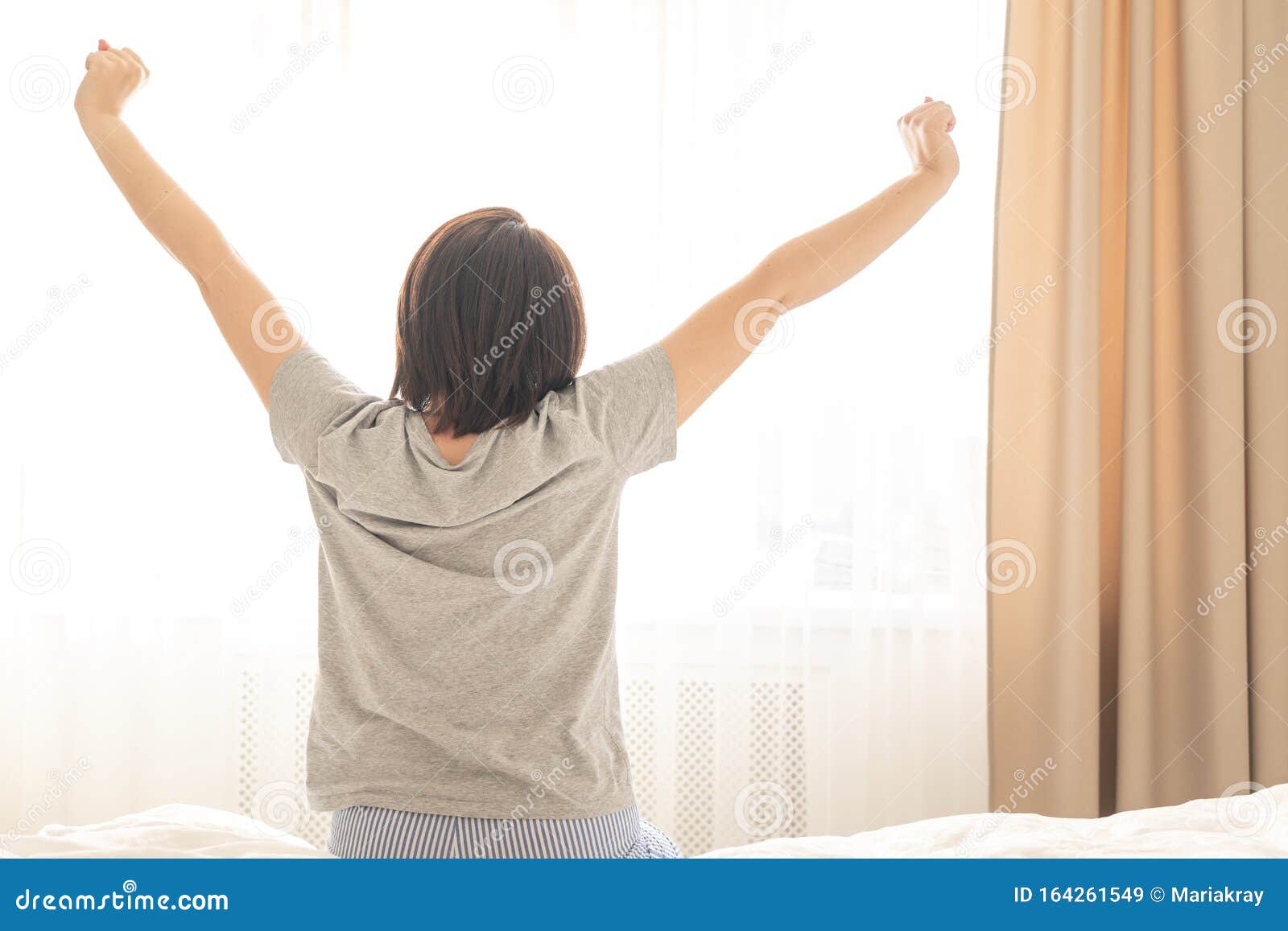Young Woman Stretching In Bed After Wake Up Back View Stock Image