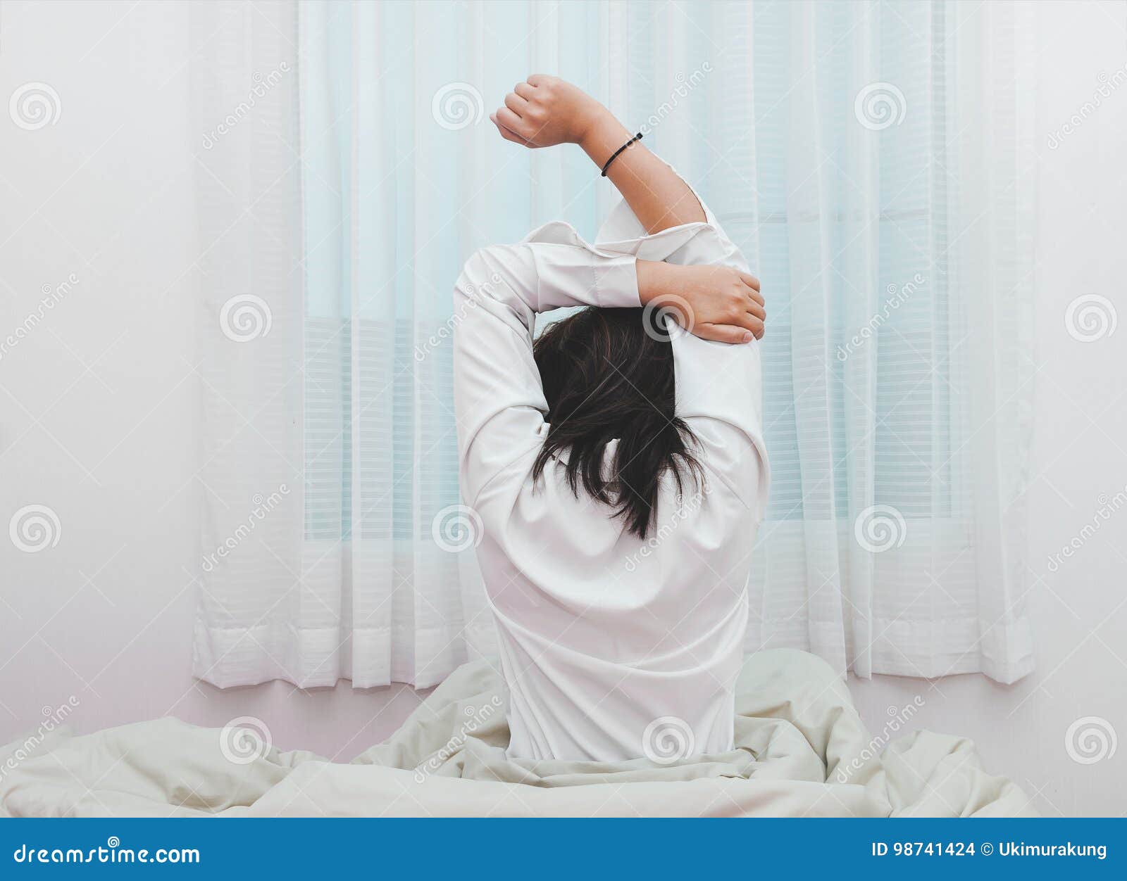 Woman Stretching in Bed after Waking Up, Back View, Stock Photo - Image ...
