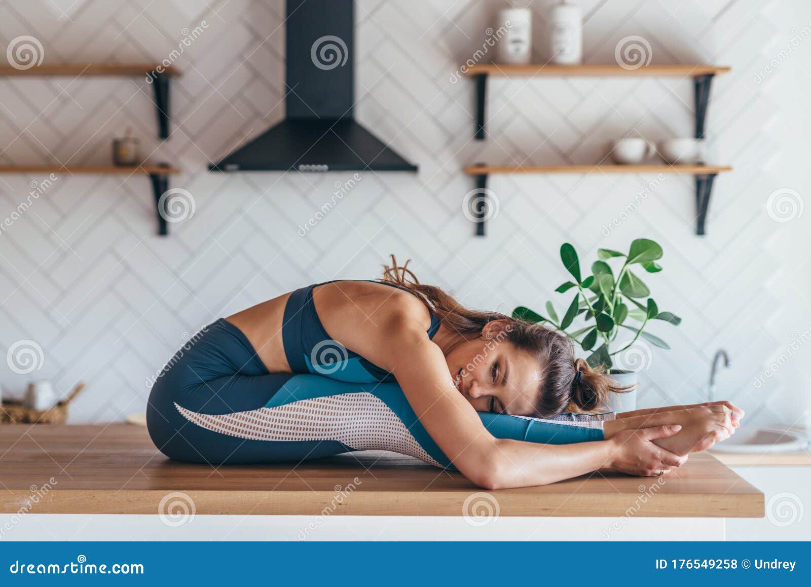Woman Stretching, Doing Seated Forward Bend on a Table Stock Photo ...