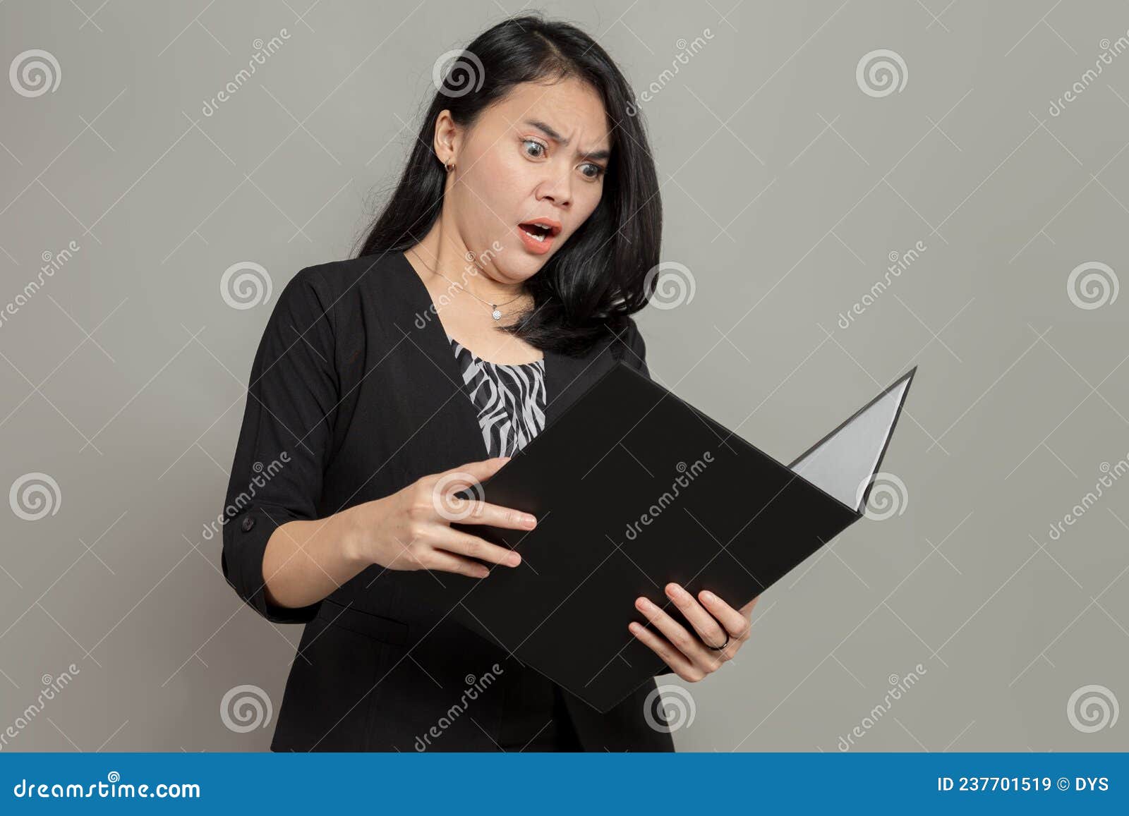Woman in Suit with Angry Shocked Expression while Holding and Looking ...