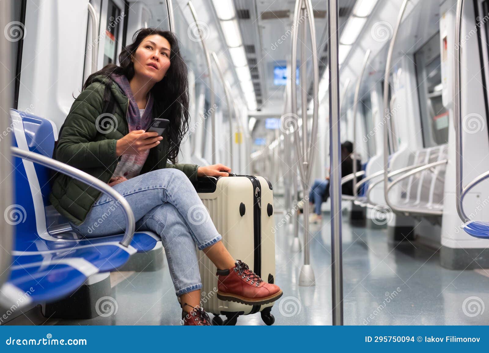 Woman with Suitcase and Sitting on Bench in Subway Train and Using ...
