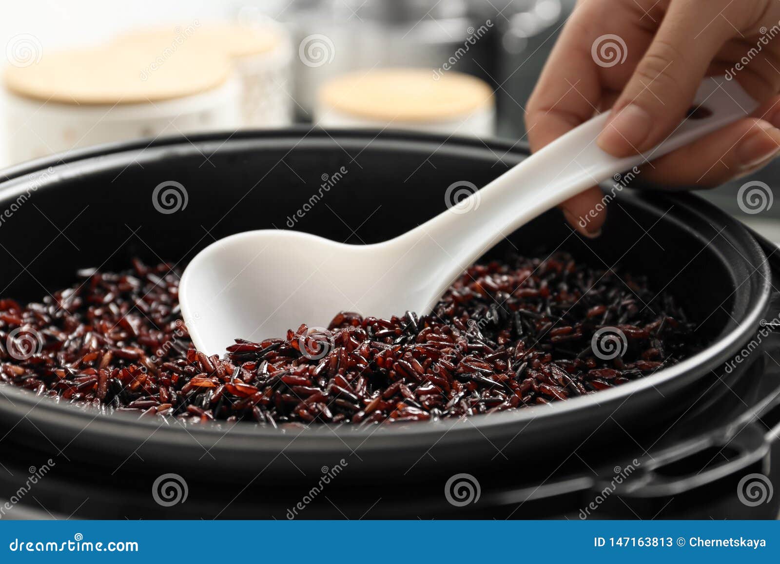 Woman Taking Brown Rice from Multi Cooker with Spoon in Kitchen Stock ...