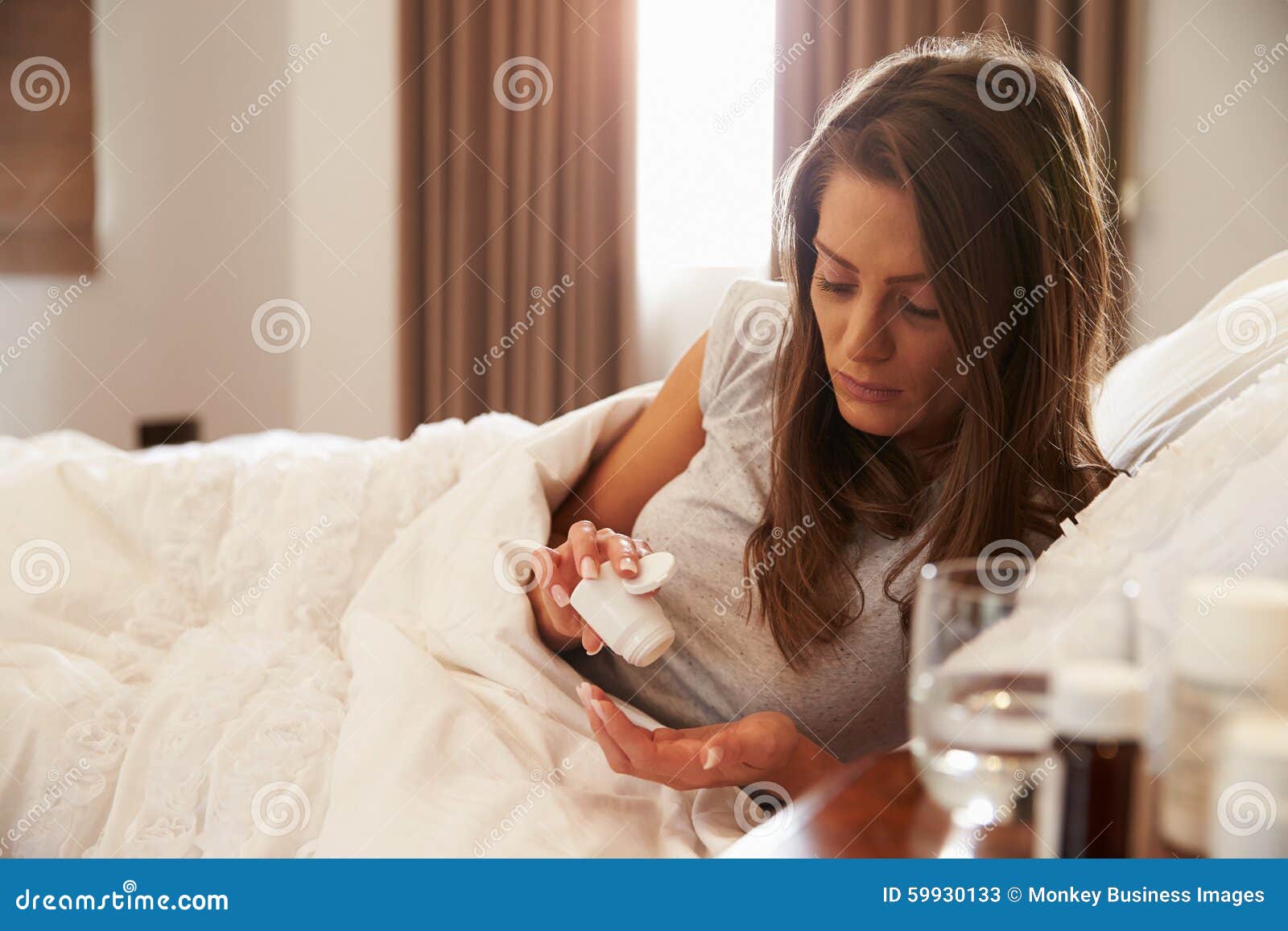 Woman Taking Medication from Containers on Bedside Table Stock Image ...