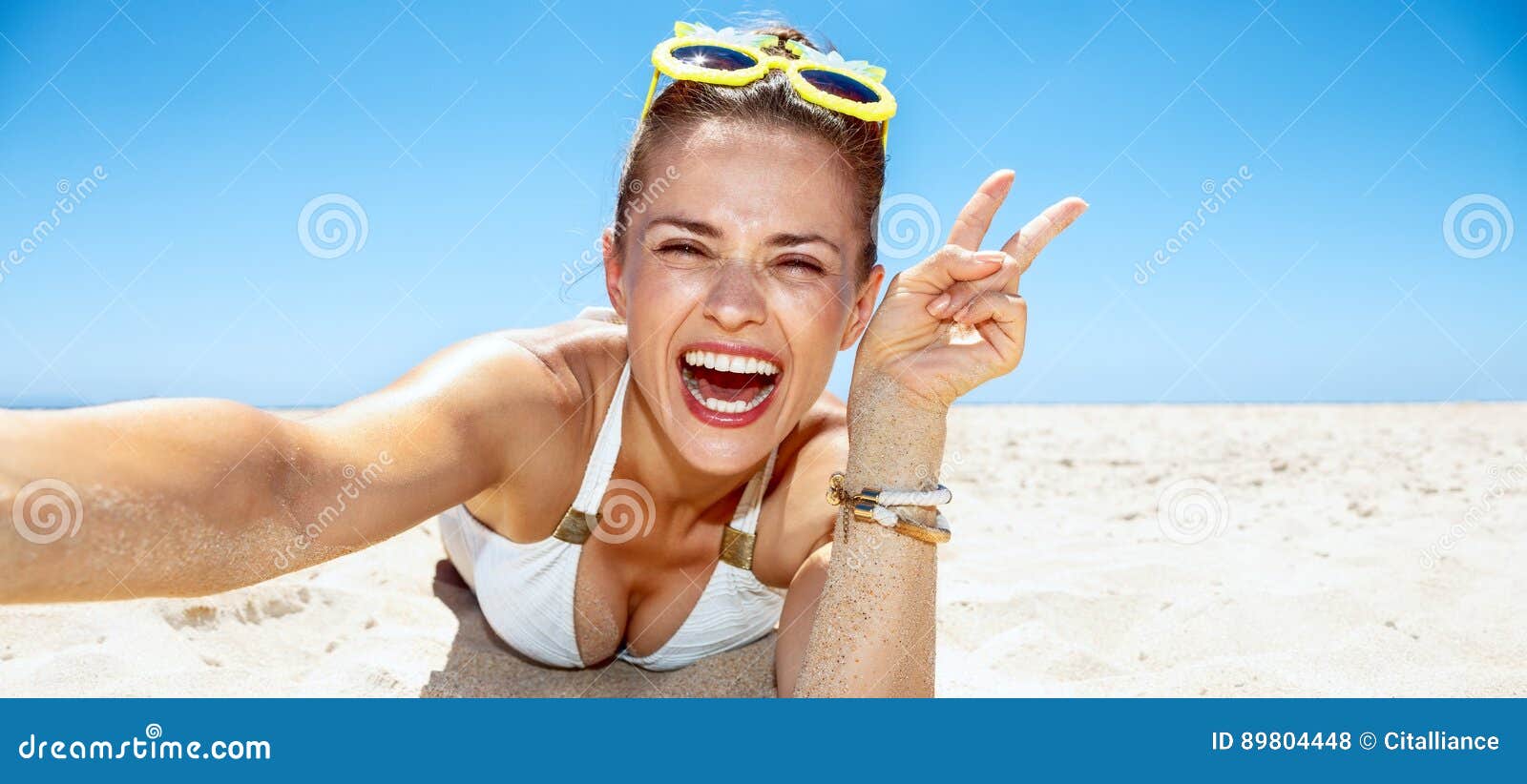 Woman Taking Selfies And Showing Victory Gesture At Sandy Beach Stock