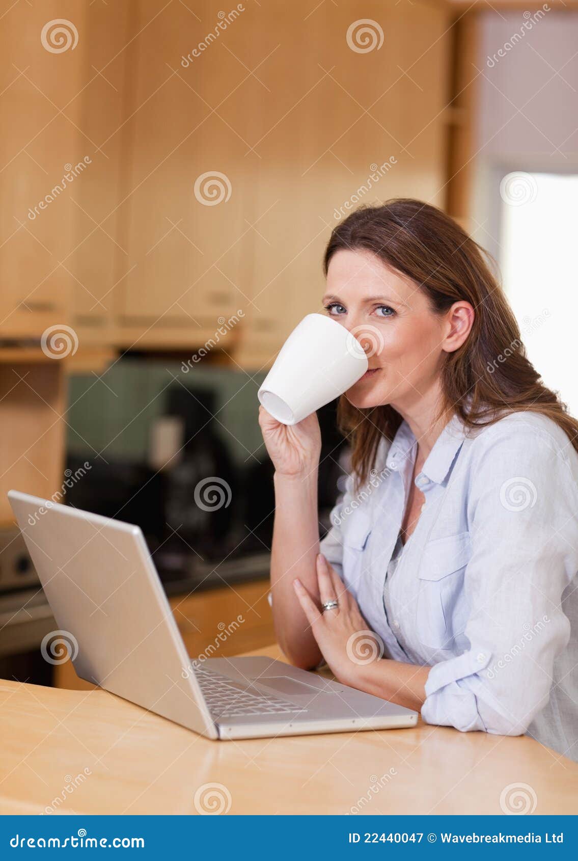 Woman Taking a Sip of Coffee Next To Laptop Stock Image - Image of ...