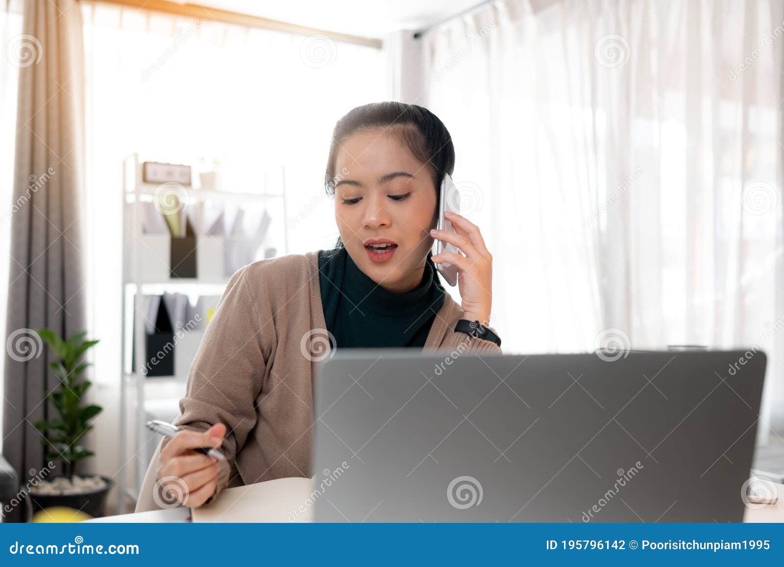 Woman Talking with Someone on Mobile Phone while Writing on Notebook ...