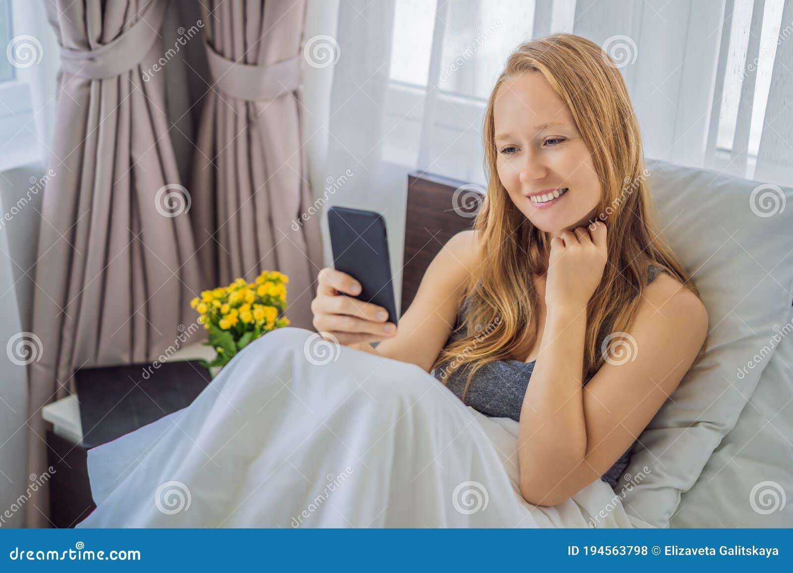 Woman Talking by Video Call while Lying in Bed Stock Photo - Image of ...
