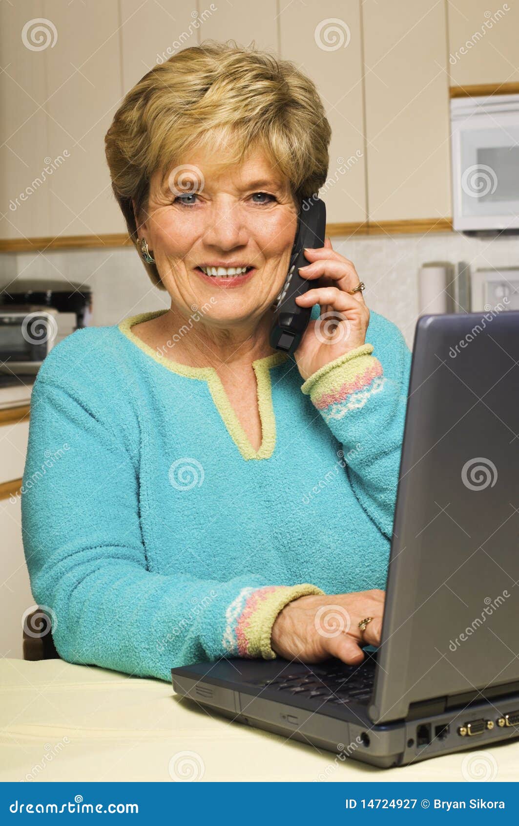 Woman Talks on Phone while Working on Laptop Stock Image - Image of ...