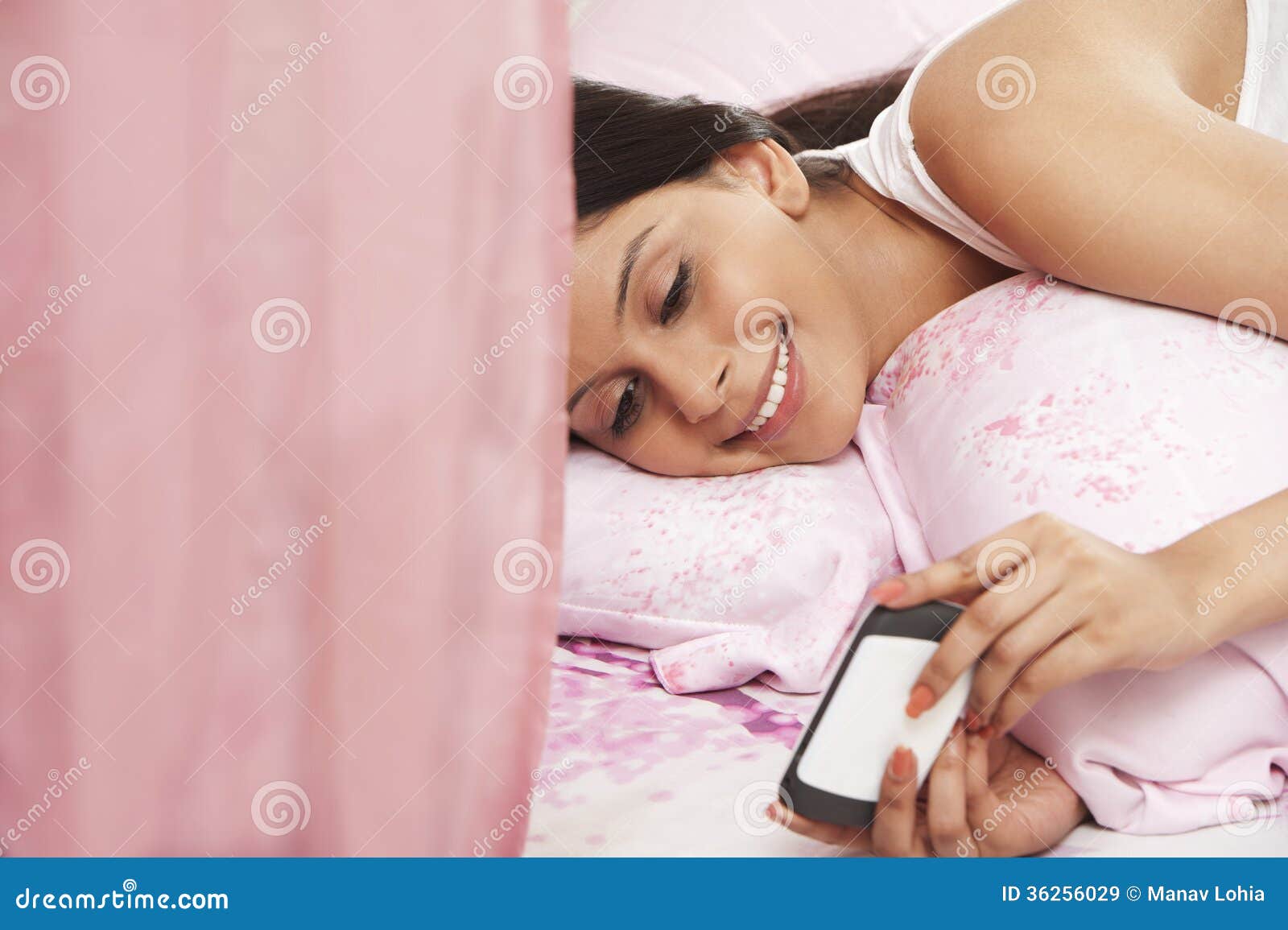 Woman Text Messaging On A Mobile Phone On The Bed Stock Image Image