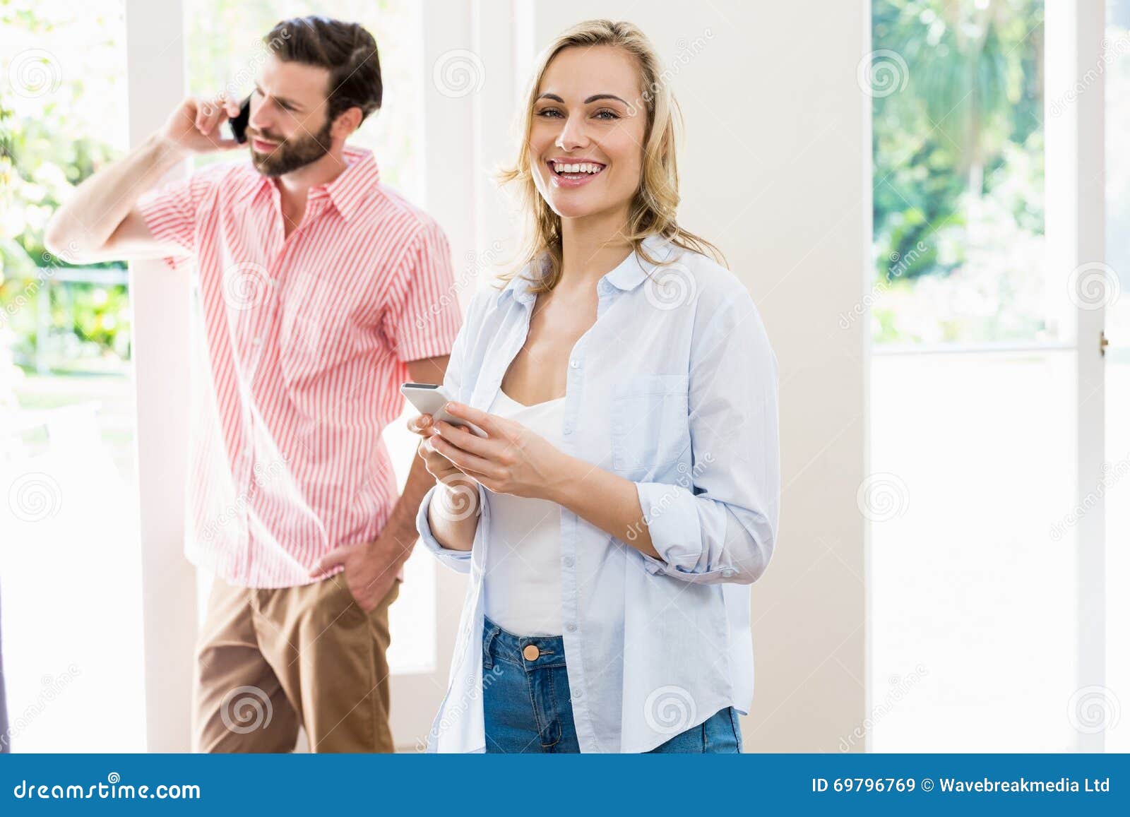 Woman Texting Messaging while Man Talking on Mobile Phone Stock Image ...