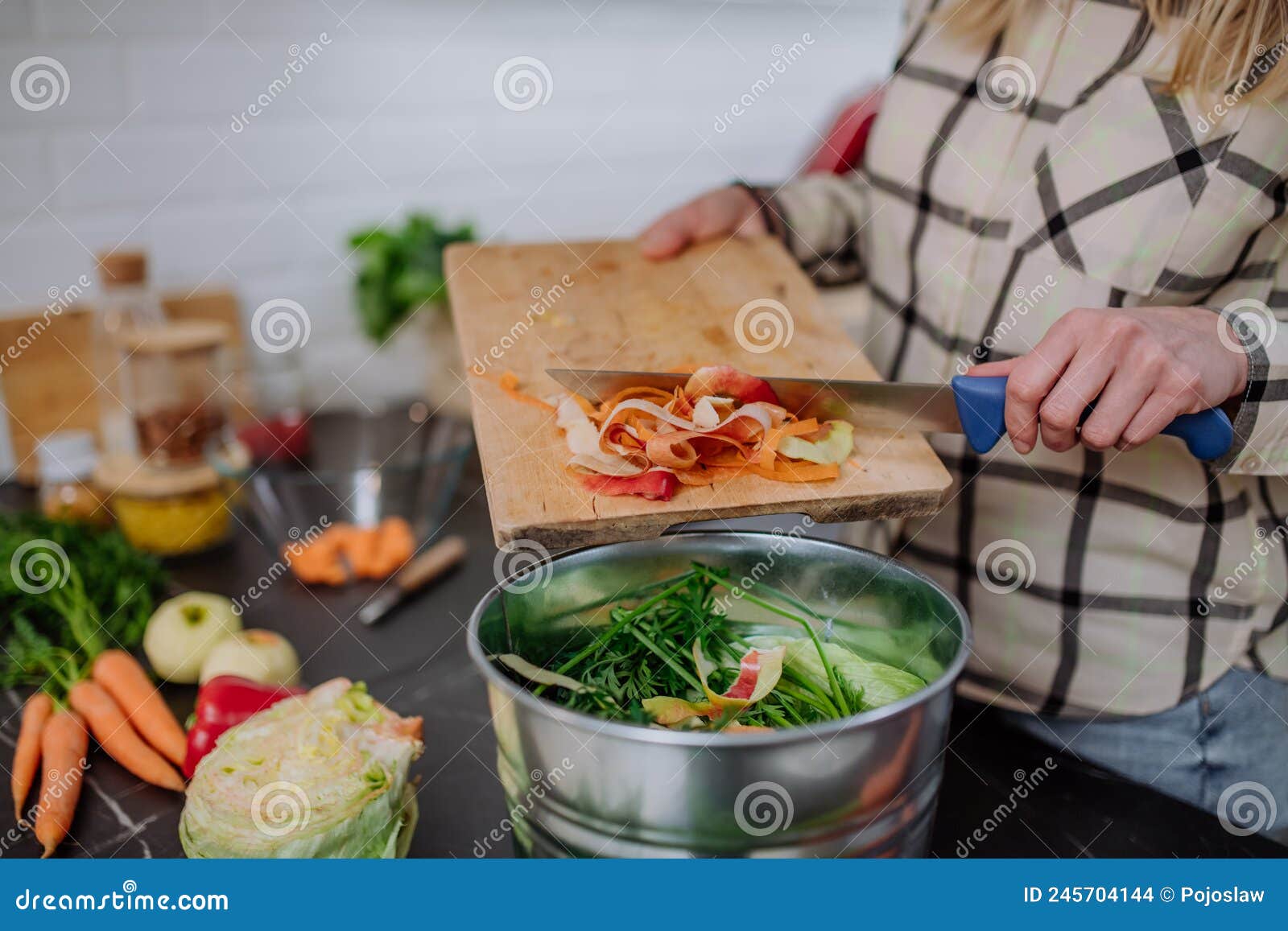 Woman Throwing Vegetable Cuttings in a Compost Bucket in Kitchen. Stock ...