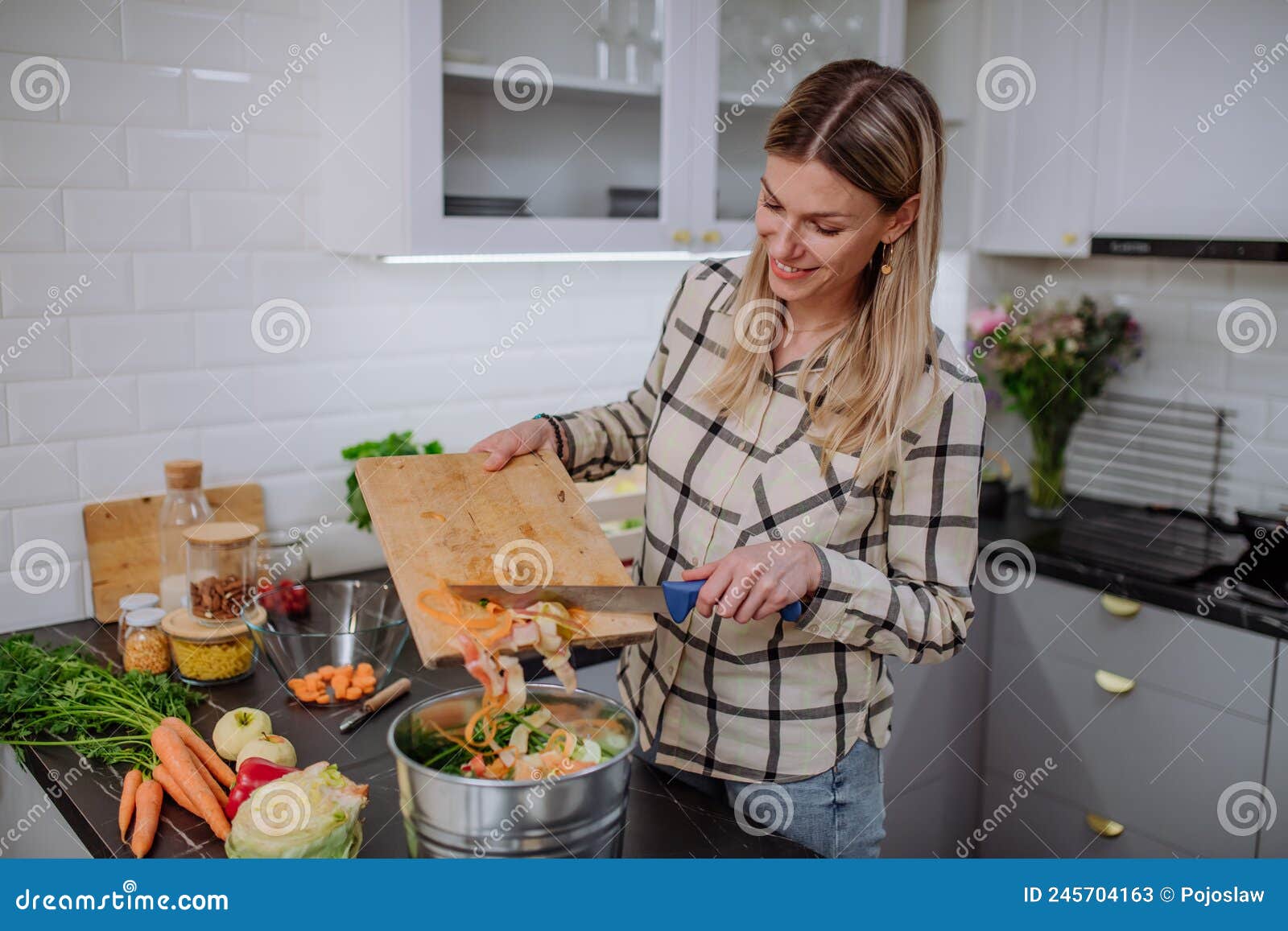Woman Throwing Vegetable Cuttings in a Compost Bucket in Kitchen. Stock ...