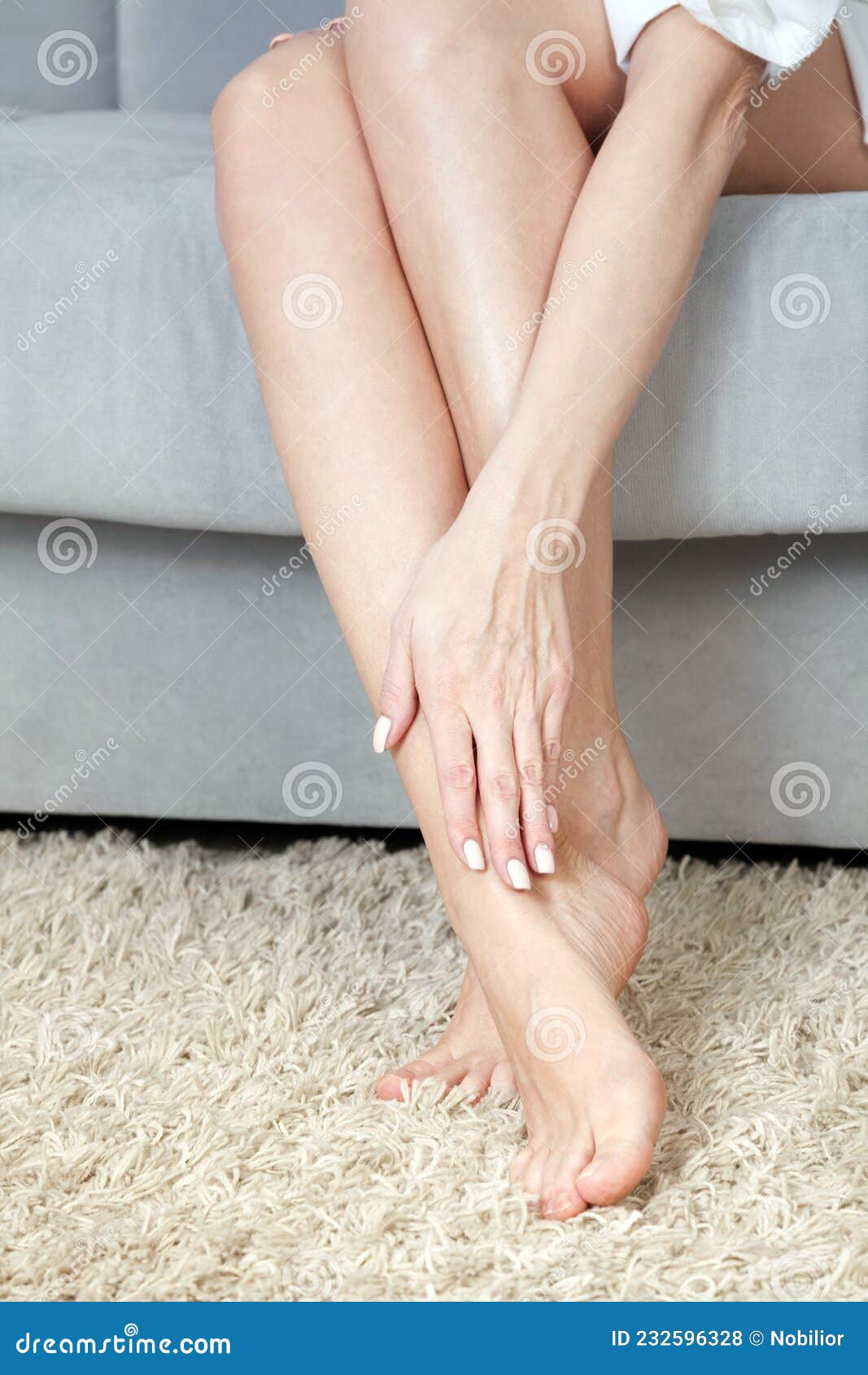 Woman is touching her legs stock photo. Image of home - 232596328