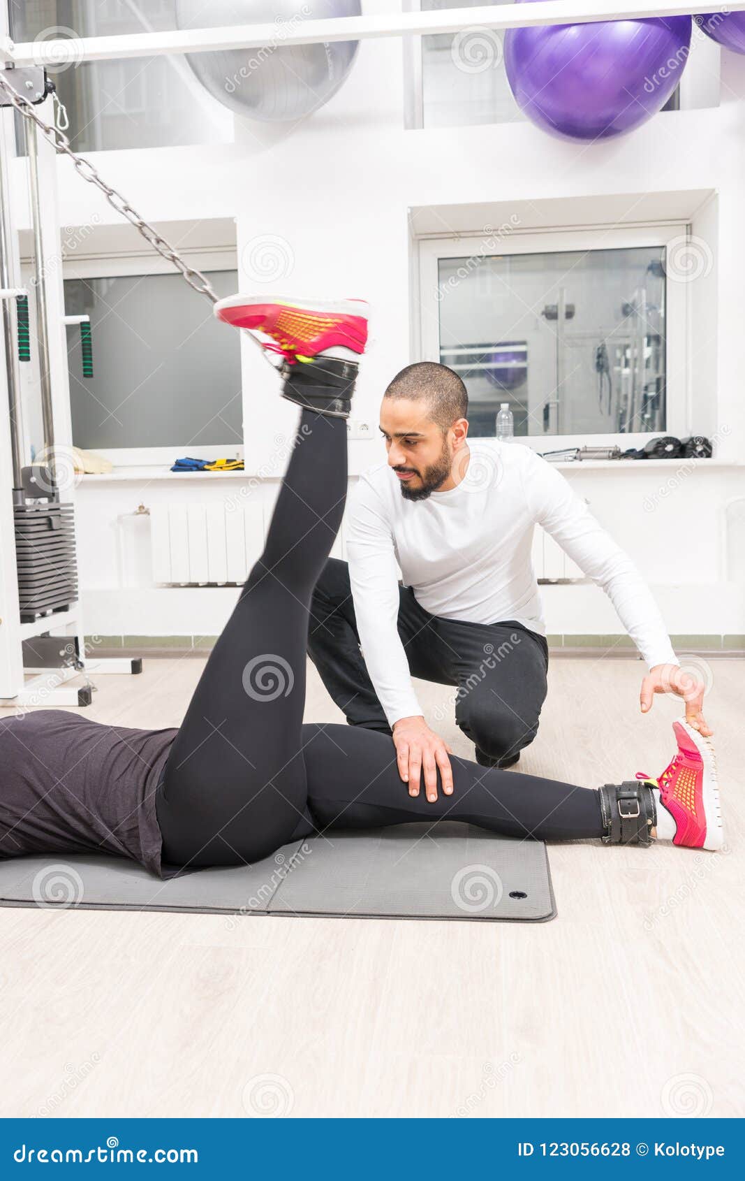Woman Exercising Legs with Personal Trainer at Gym Stock Photo - Image ...