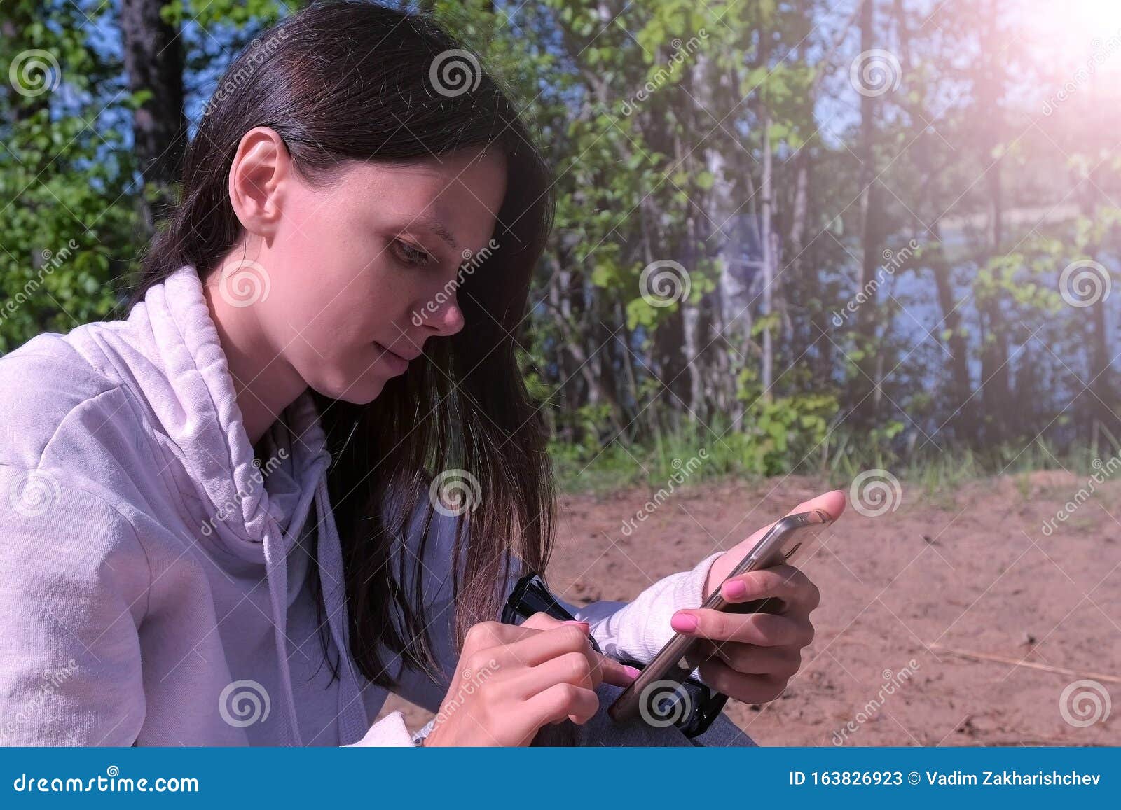 Woman Is Typing Message On Smartphone Sitting On Nature Side View Stock Image Image Of